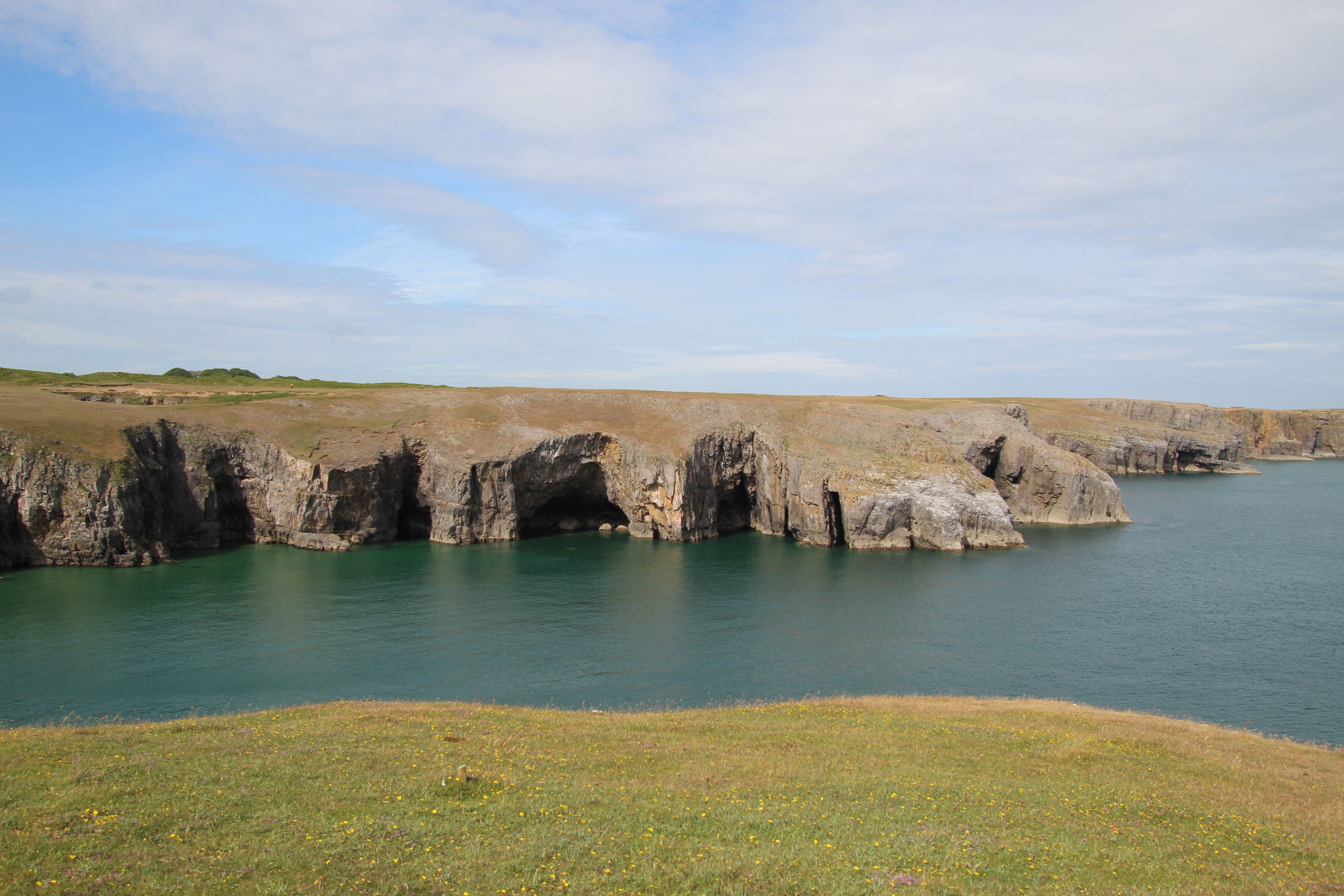 A large body of water with a cliff on the side · Free Stock Photo