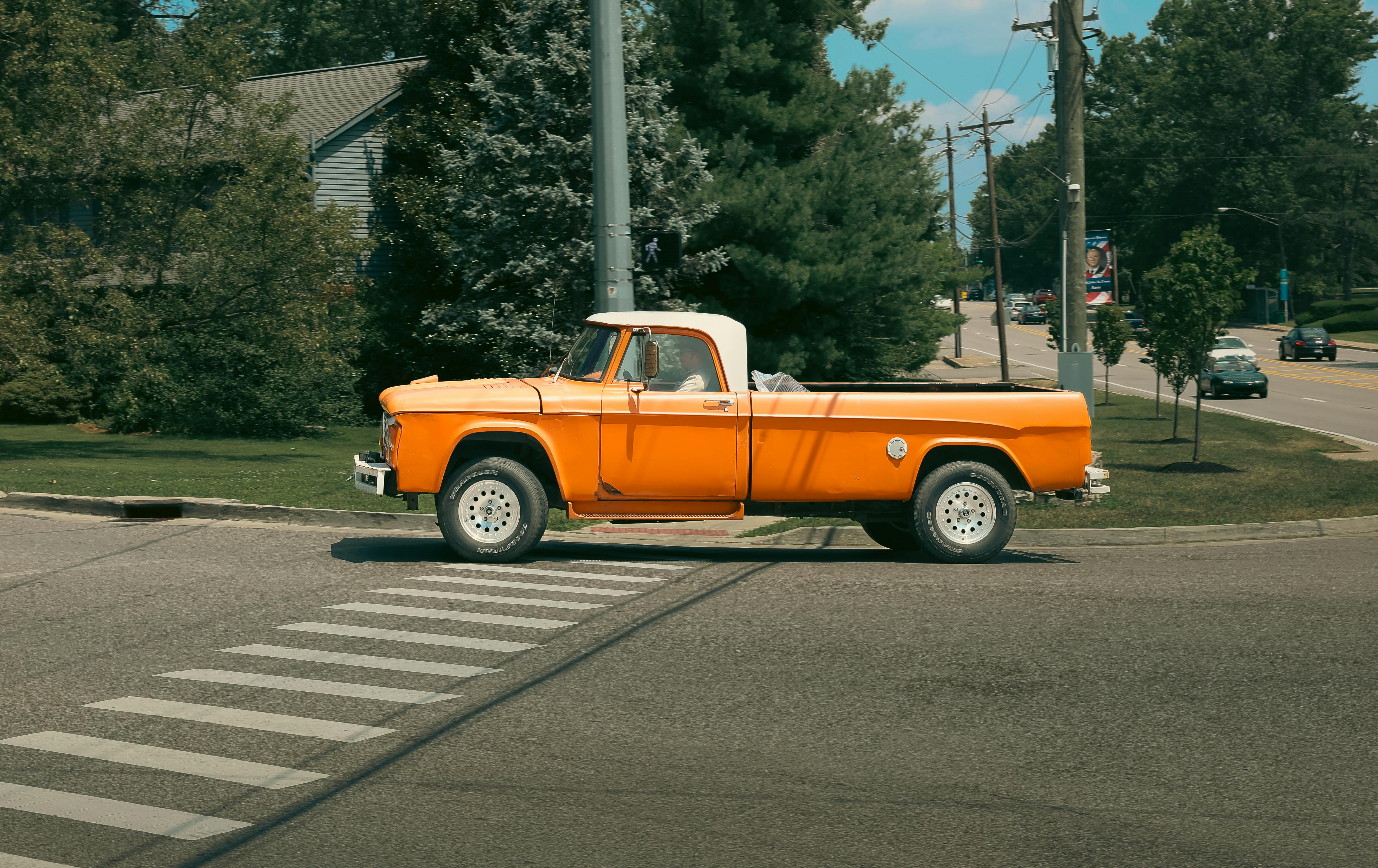 Retro car driving on city road near building · Free Stock Photo