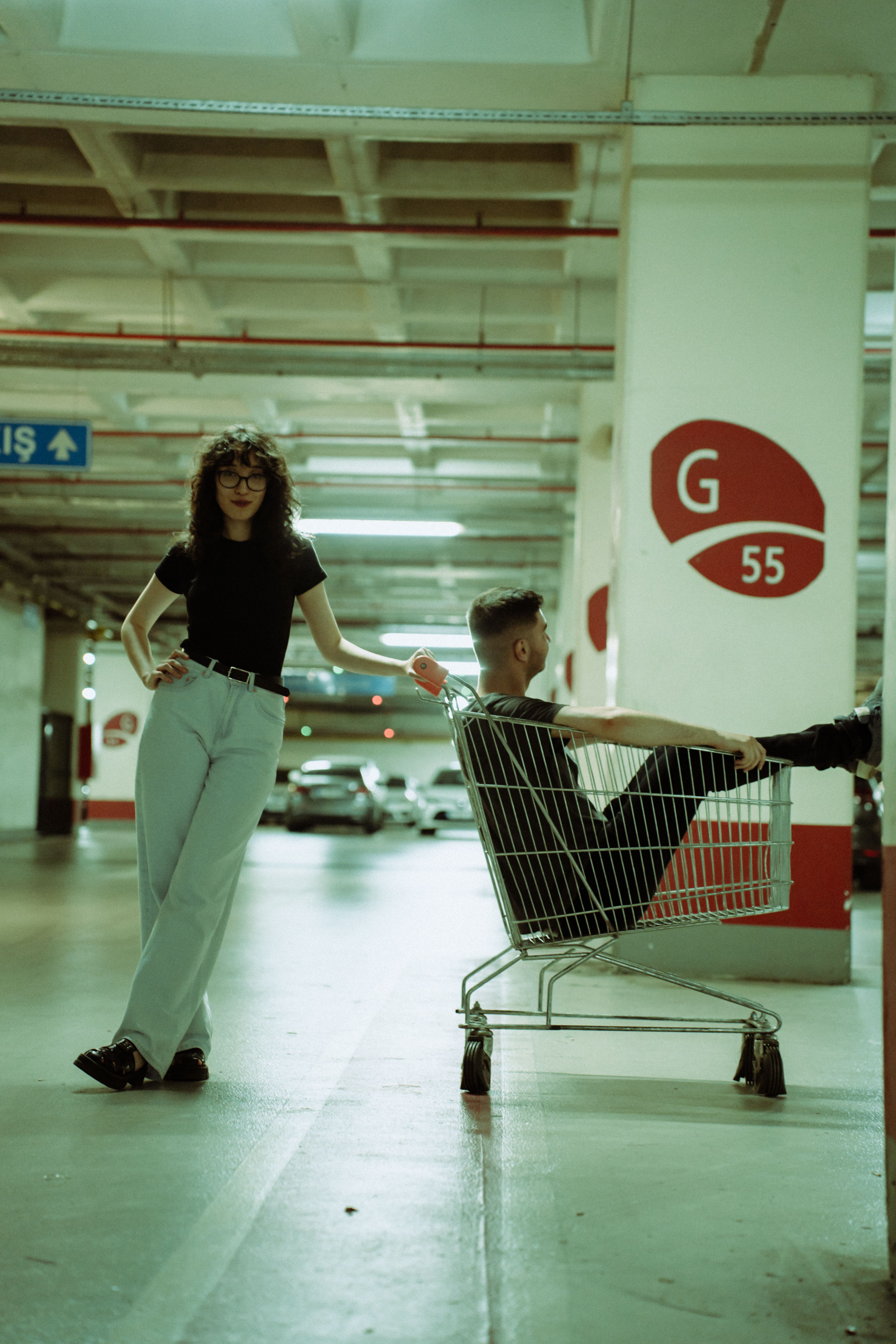 Woman Holding Hand on Shopping Cart with Man Inside · Free Stock Photo