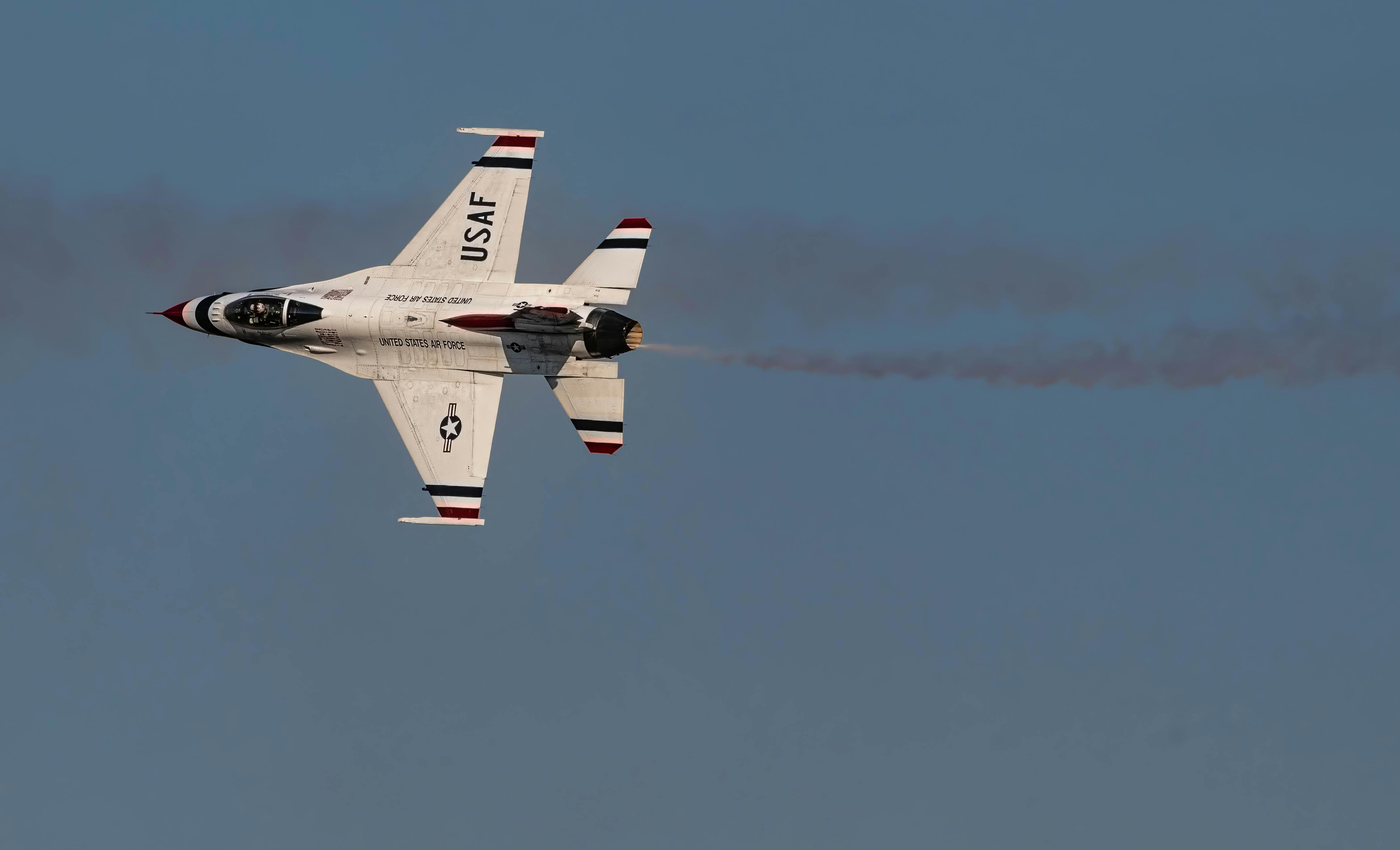 A white and red jet flying through the air · Free Stock Photo