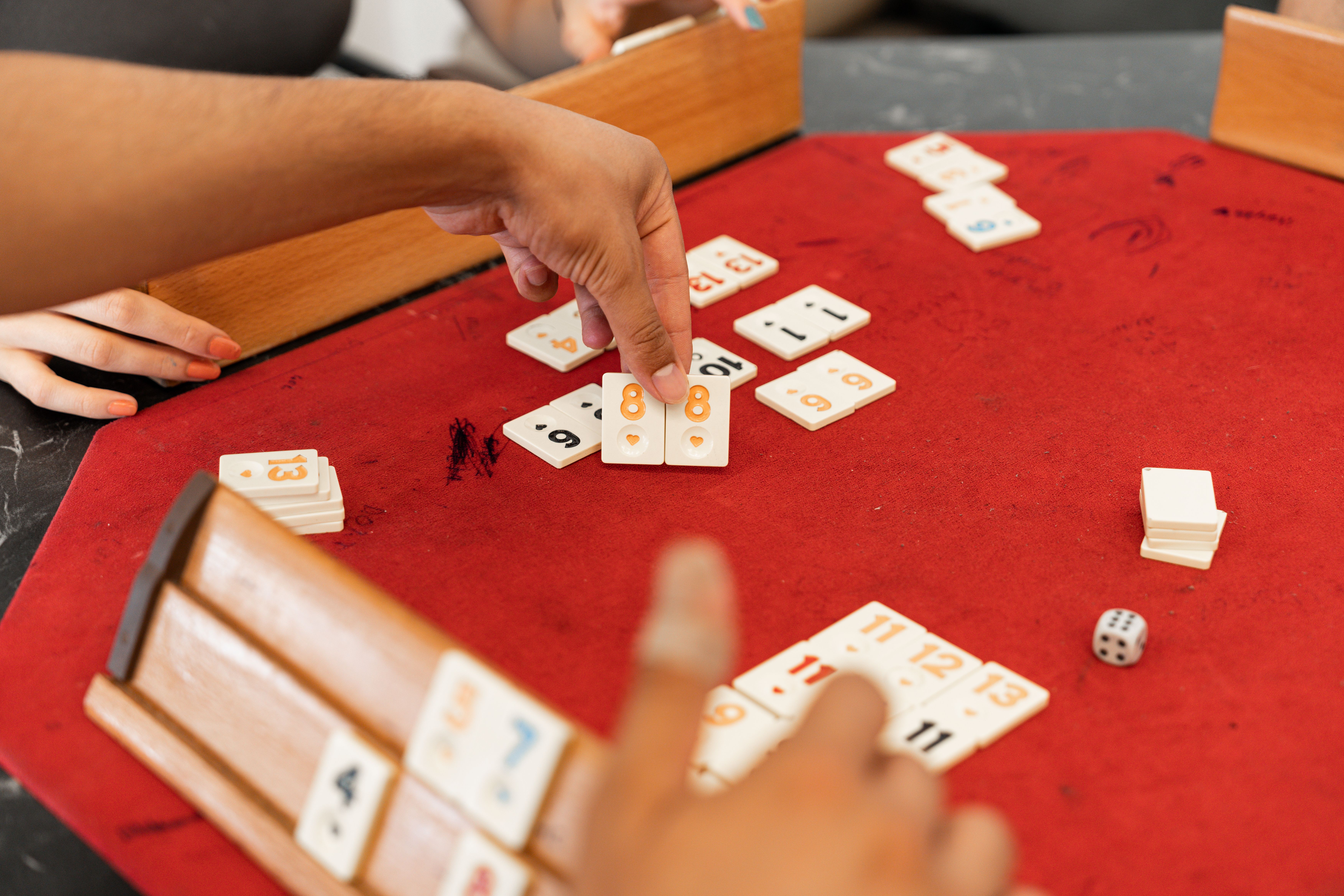 A person playing a game of mahjong on a table · Free Stock Photo