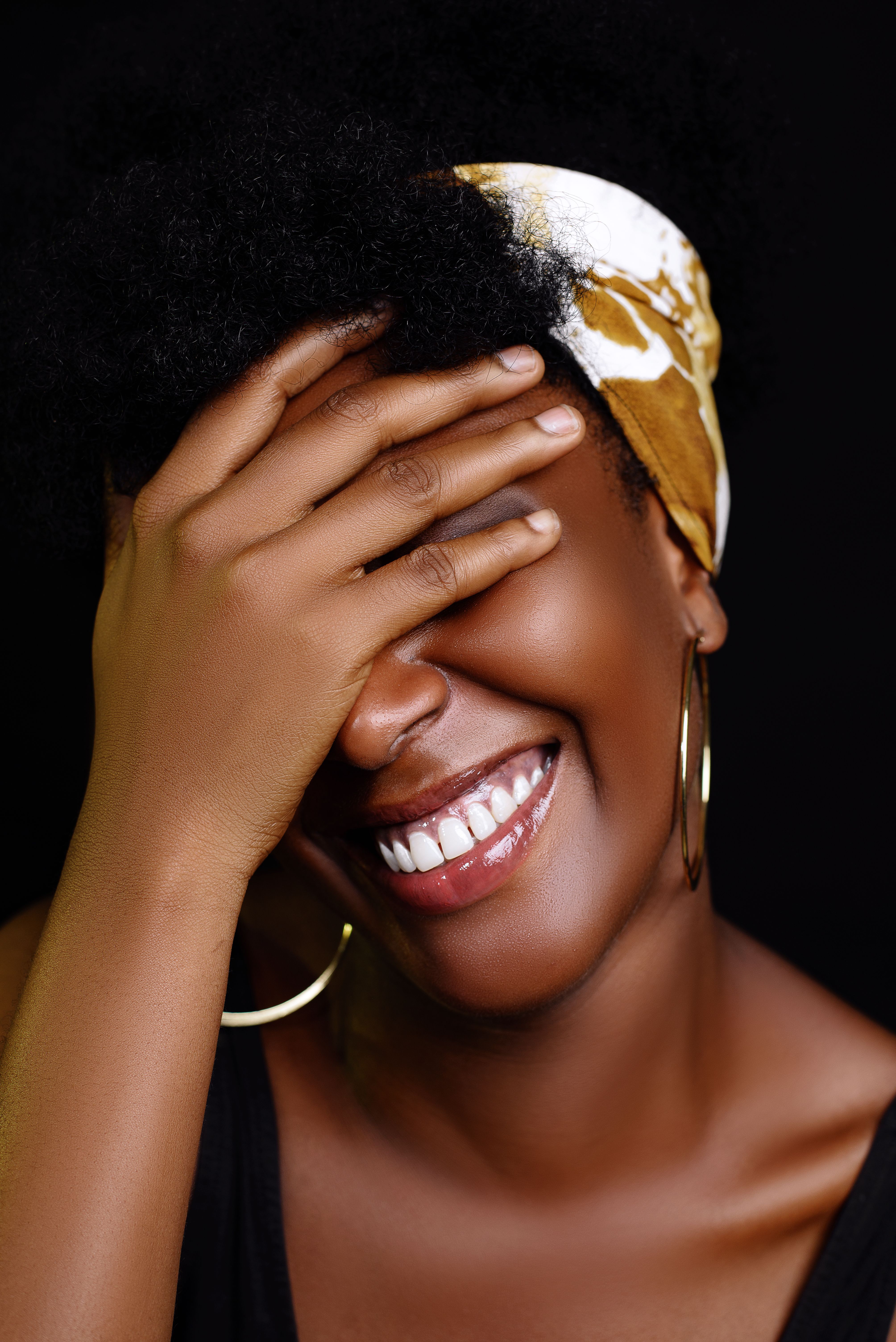 Smiling Woman with Hand on Forehead · Free Stock Photo