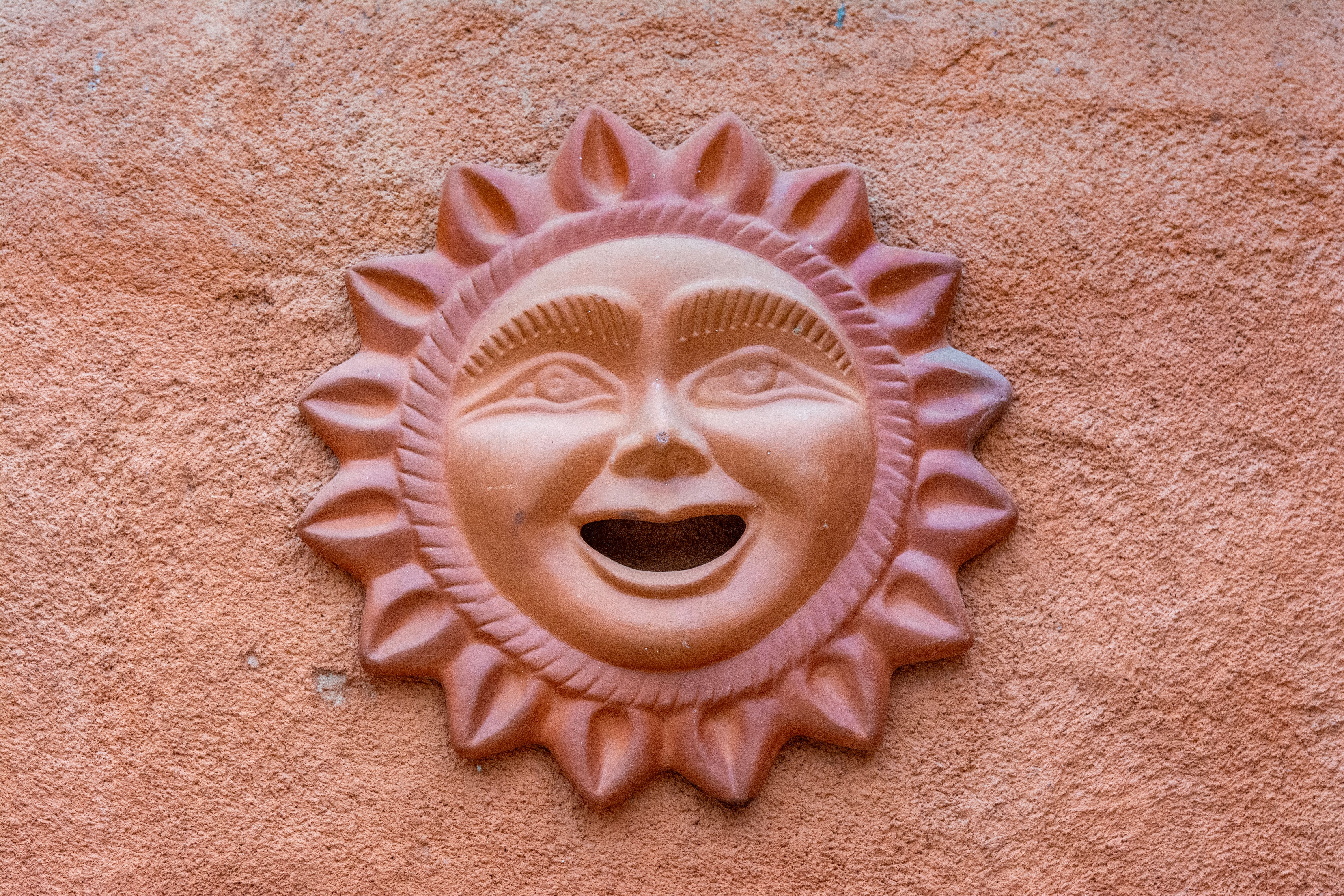 A ceramic sun with a smile on it's face · Free Stock Photo