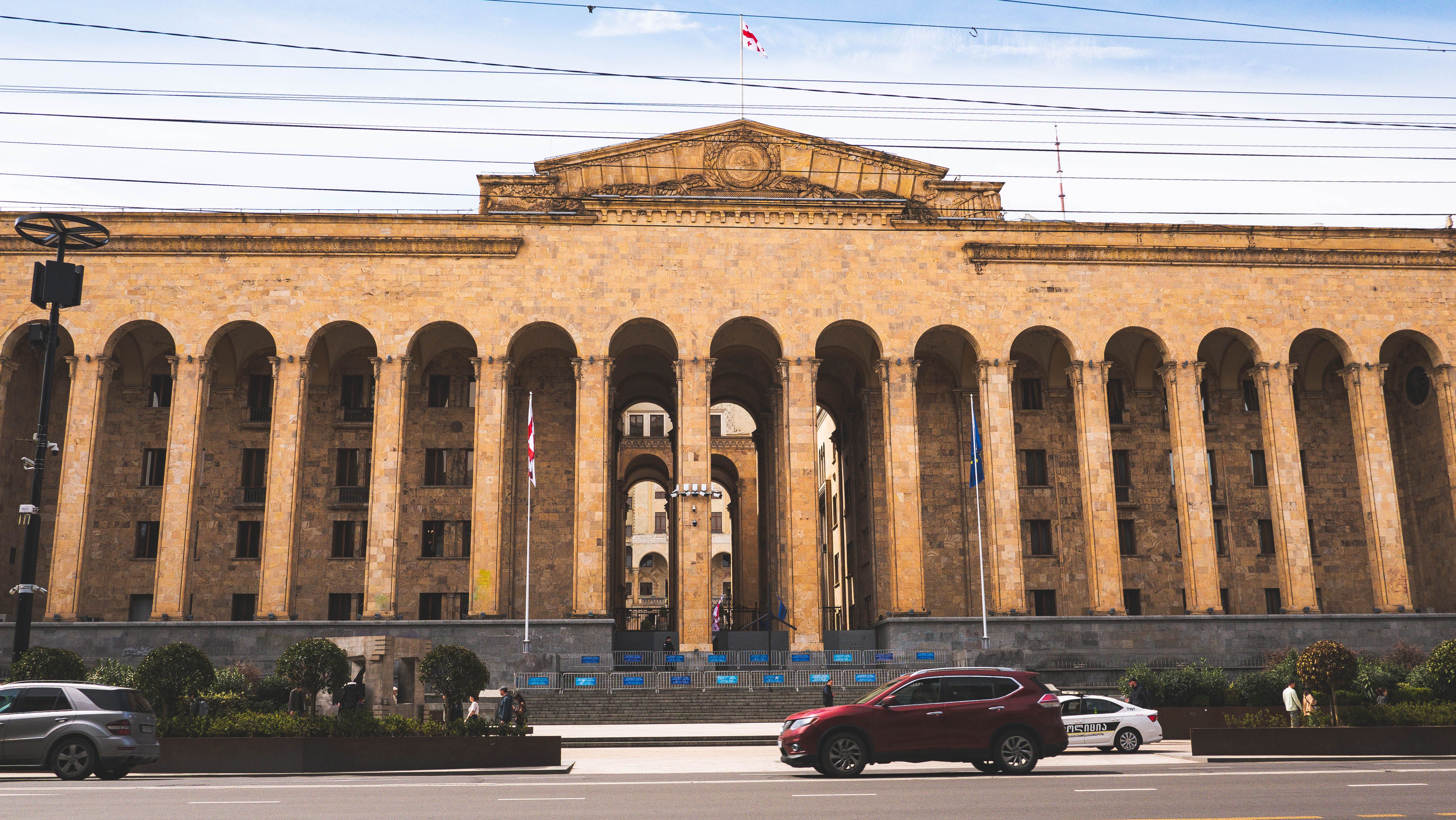 A large building with columns and cars parked in front · Free Stock Photo