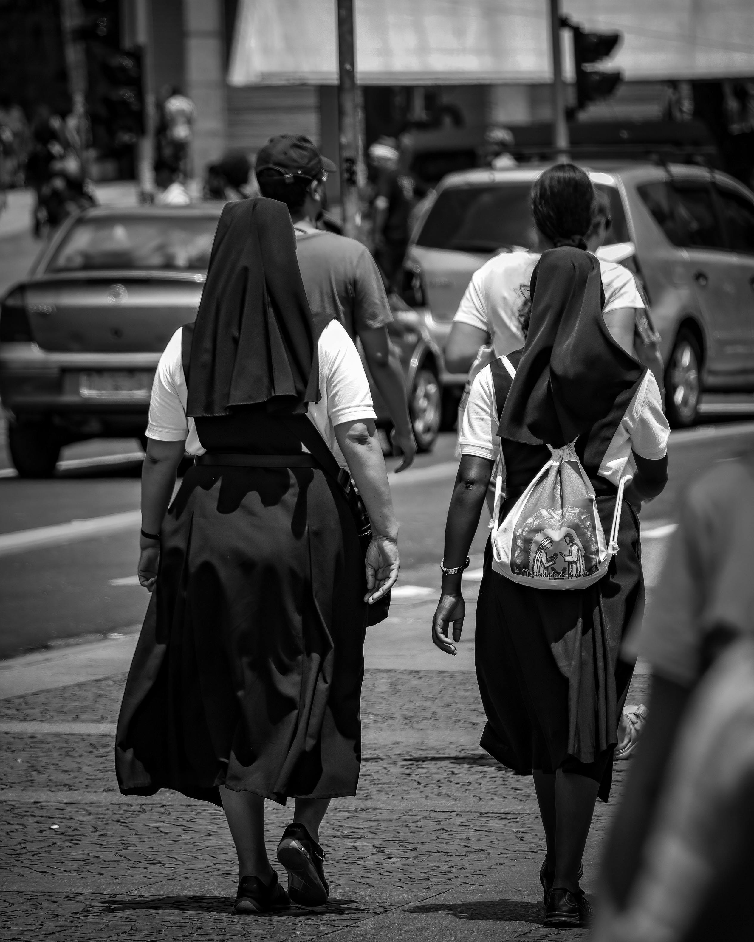 Two nuns walking down the street in black and white · Free Stock Photo