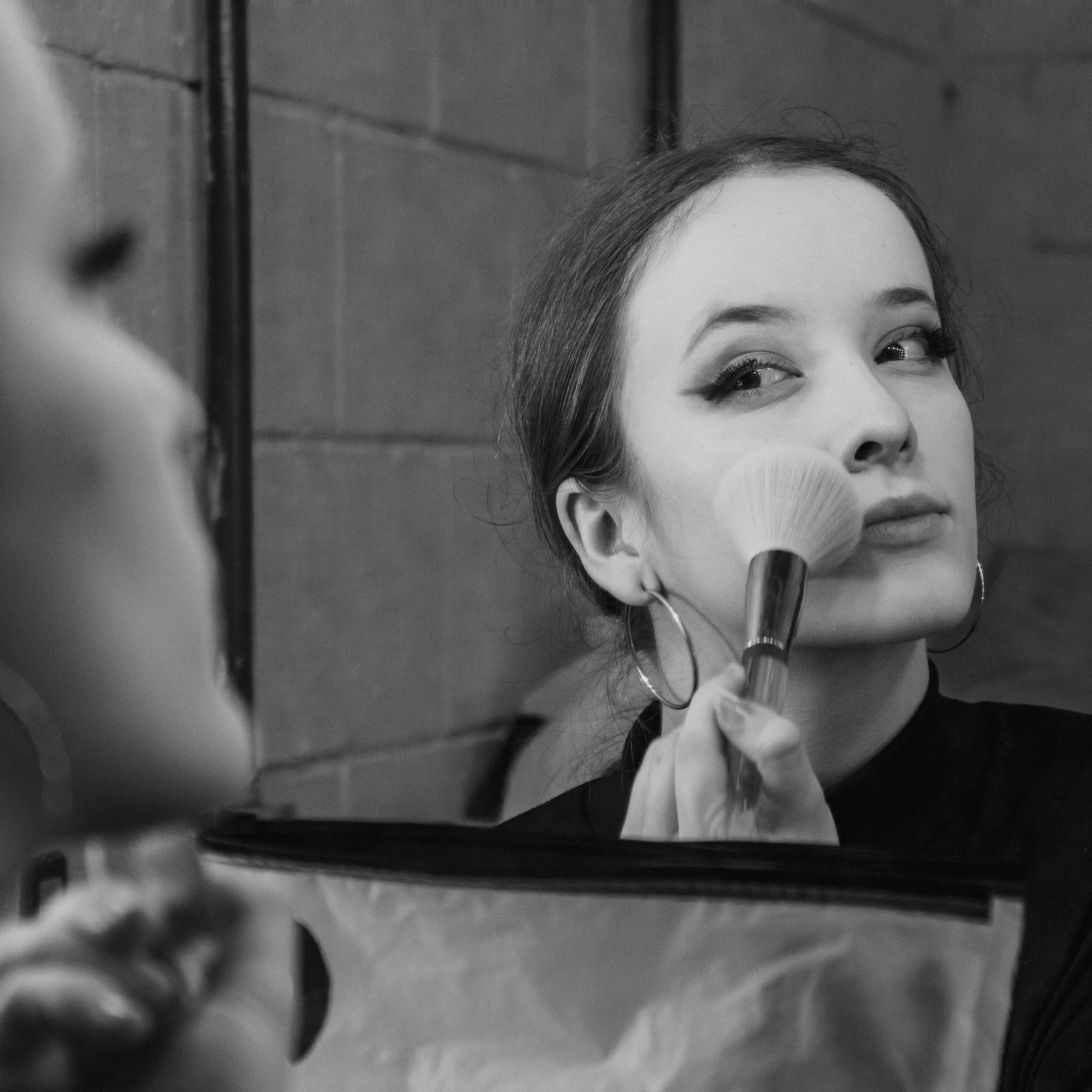 Young Woman Applying Makeup in front of a Mirror · Free Stock Photo