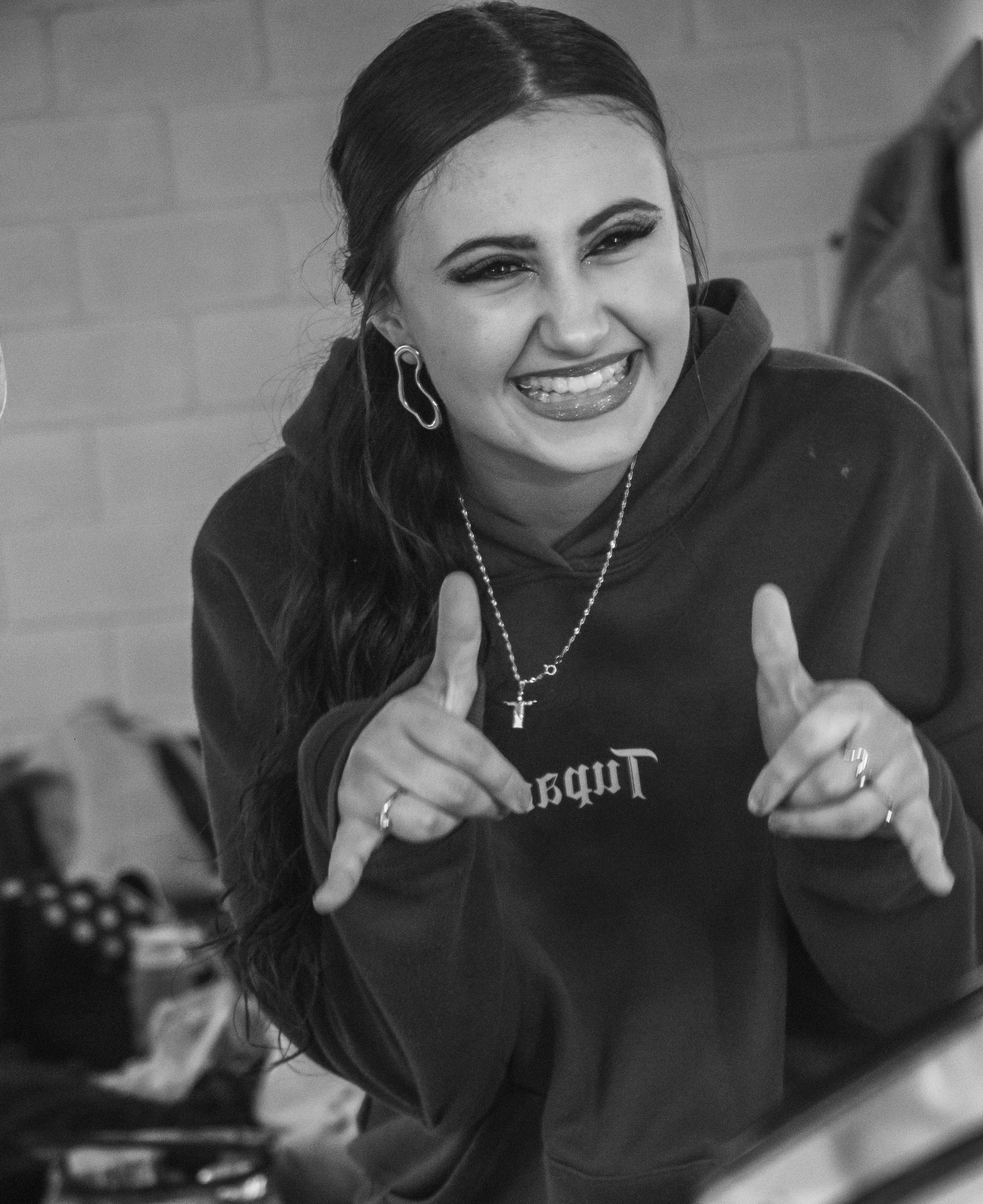 A woman in a hoodie making a peace sign · Free Stock Photo