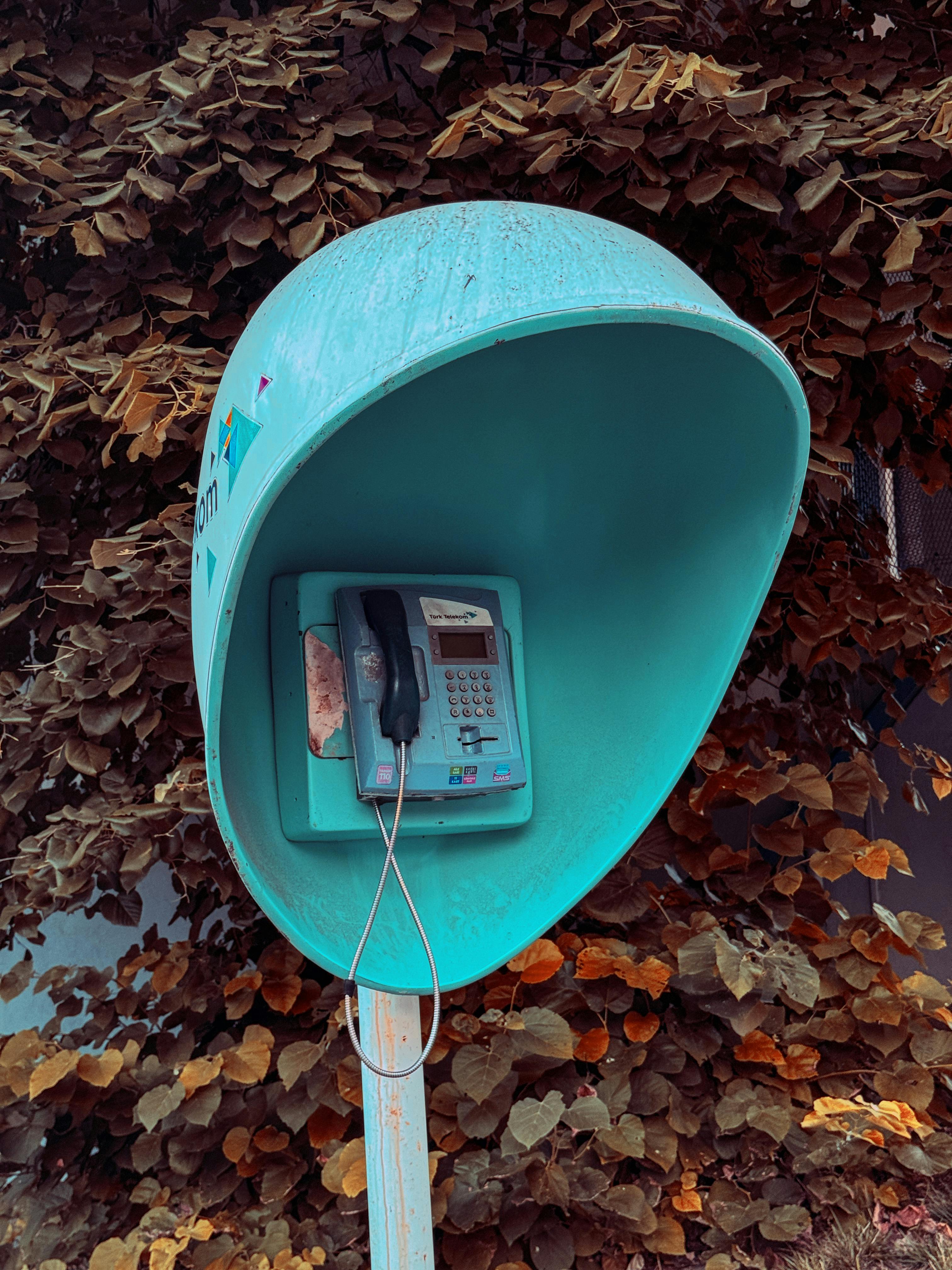 A blue telephone booth with a telephone attached to it · Free Stock Photo