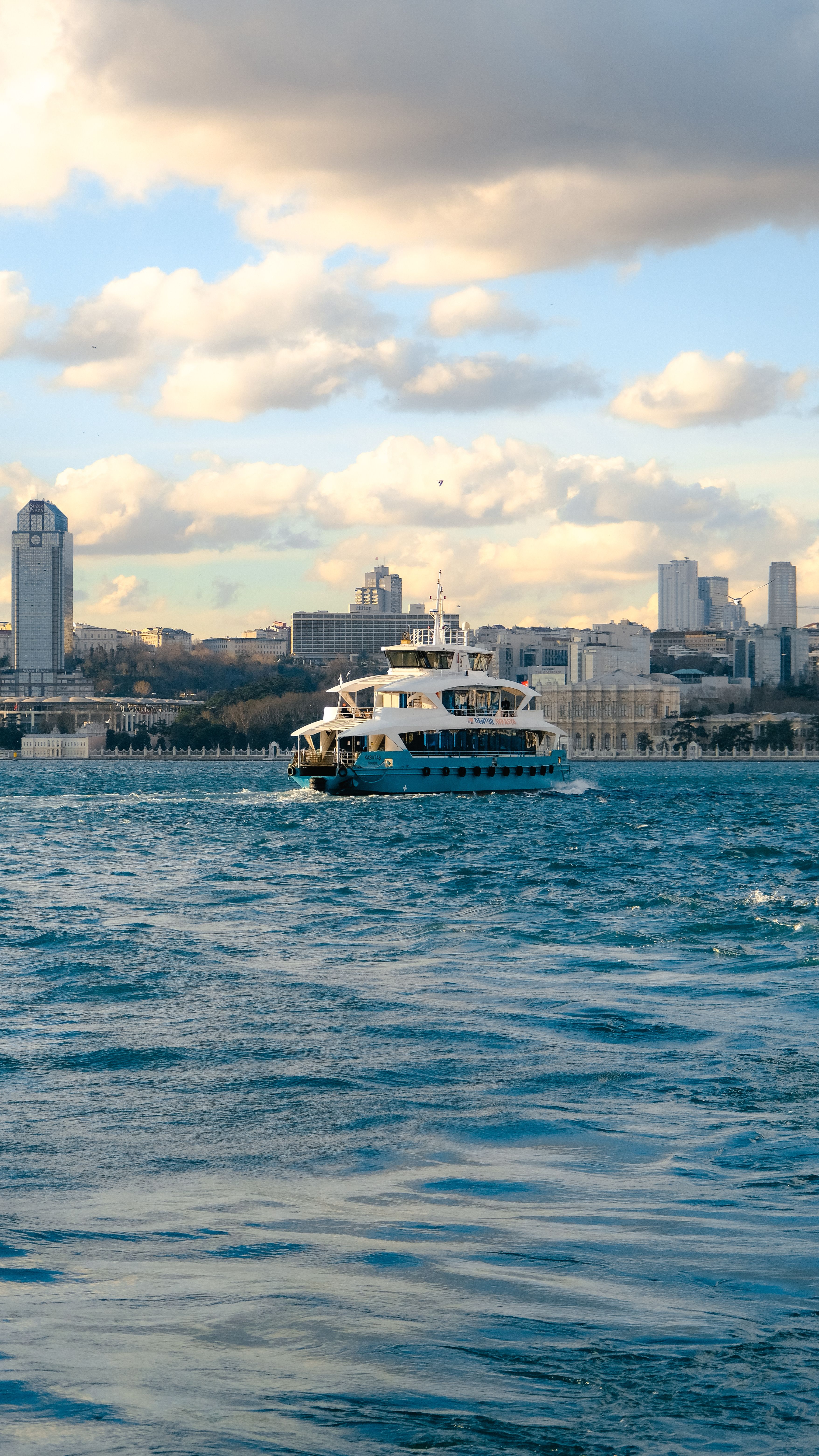A boat is traveling through the water near a city · Free Stock Photo