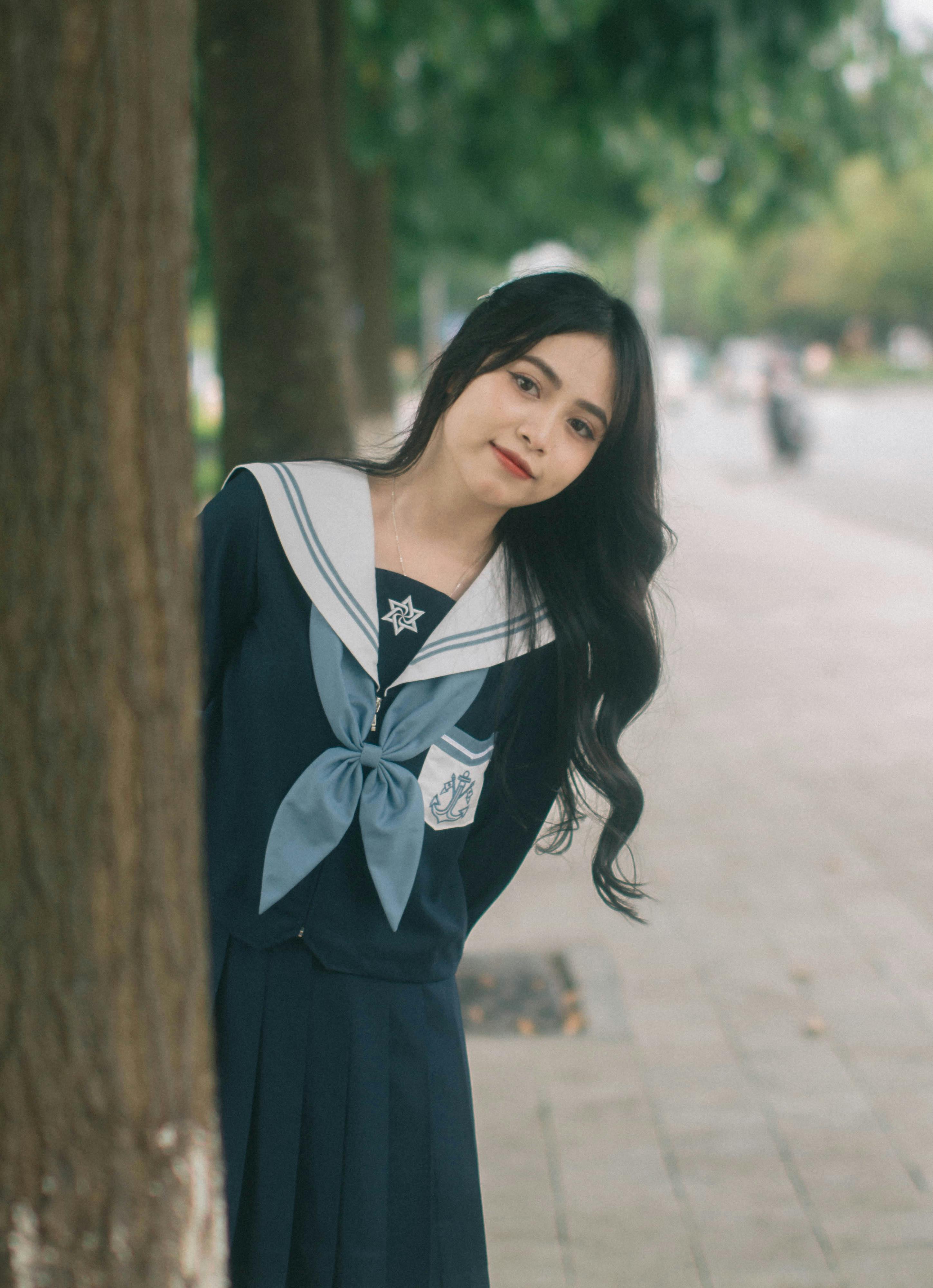 Young Model in Sailor-Style School Uniform Peeking Out from Behind a ...