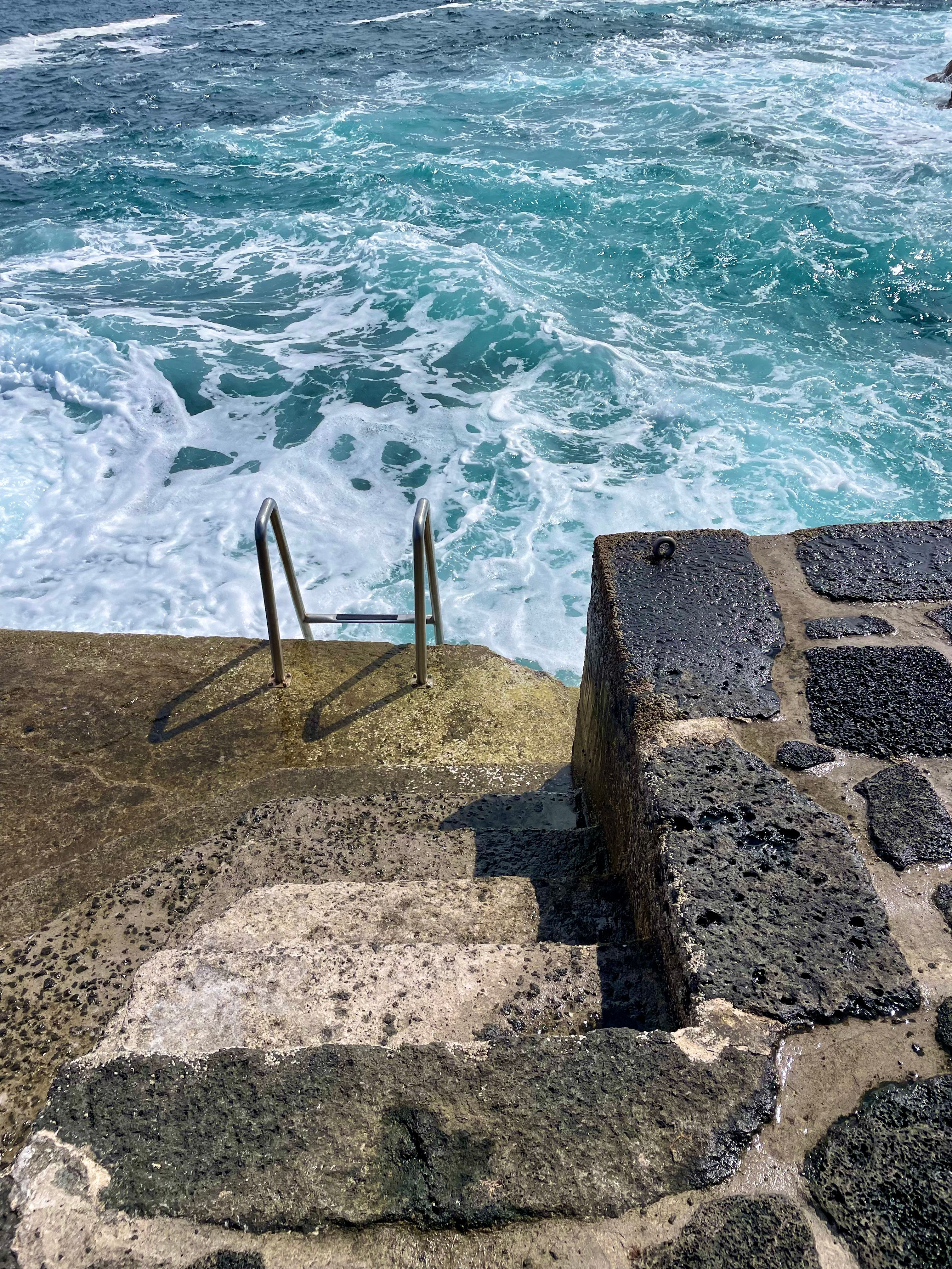 A stairway leading to the ocean with waves crashing · Free Stock Photo