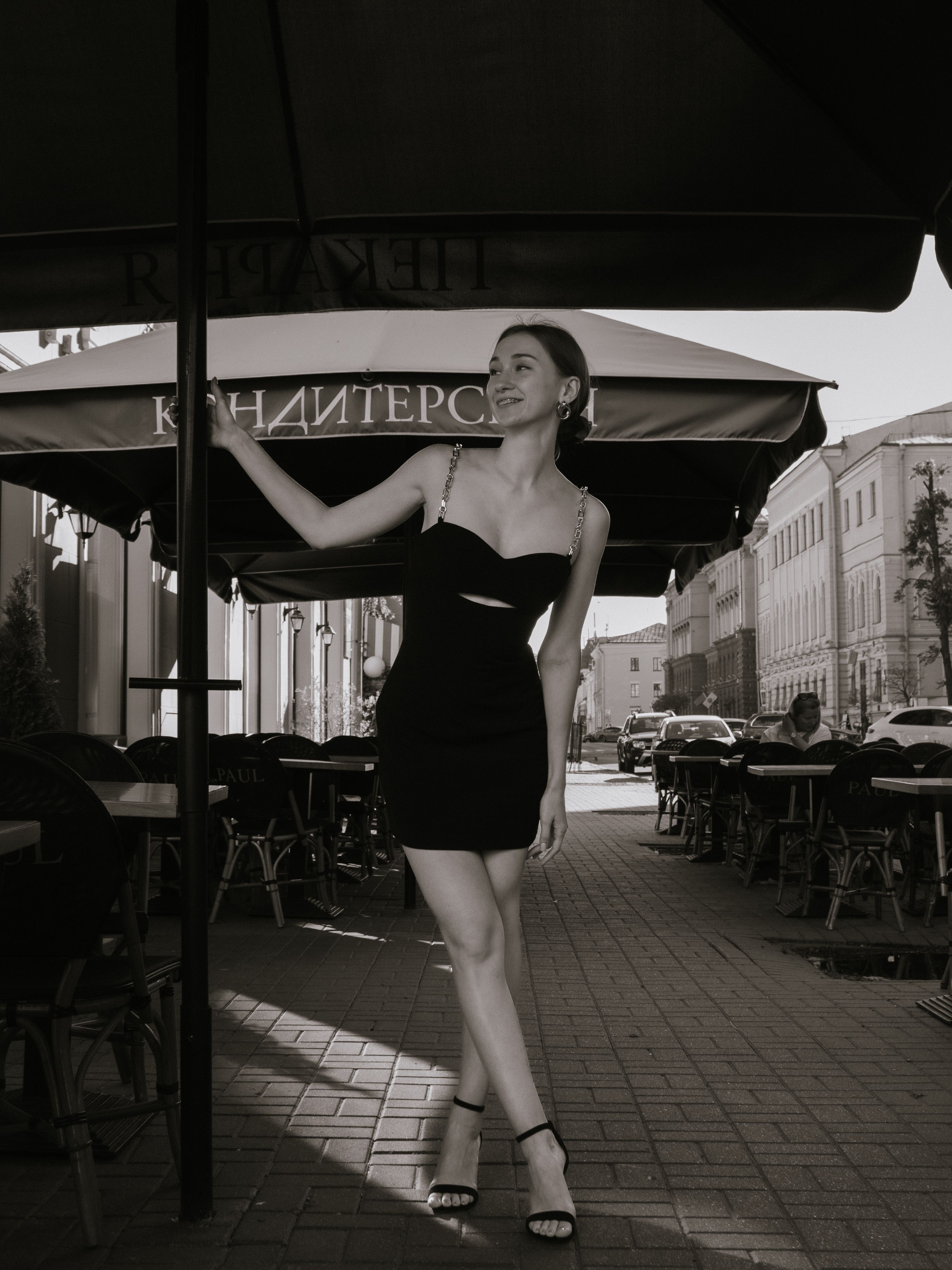 Black and White Photo of Woman in Black Dress Walking between Tables ...