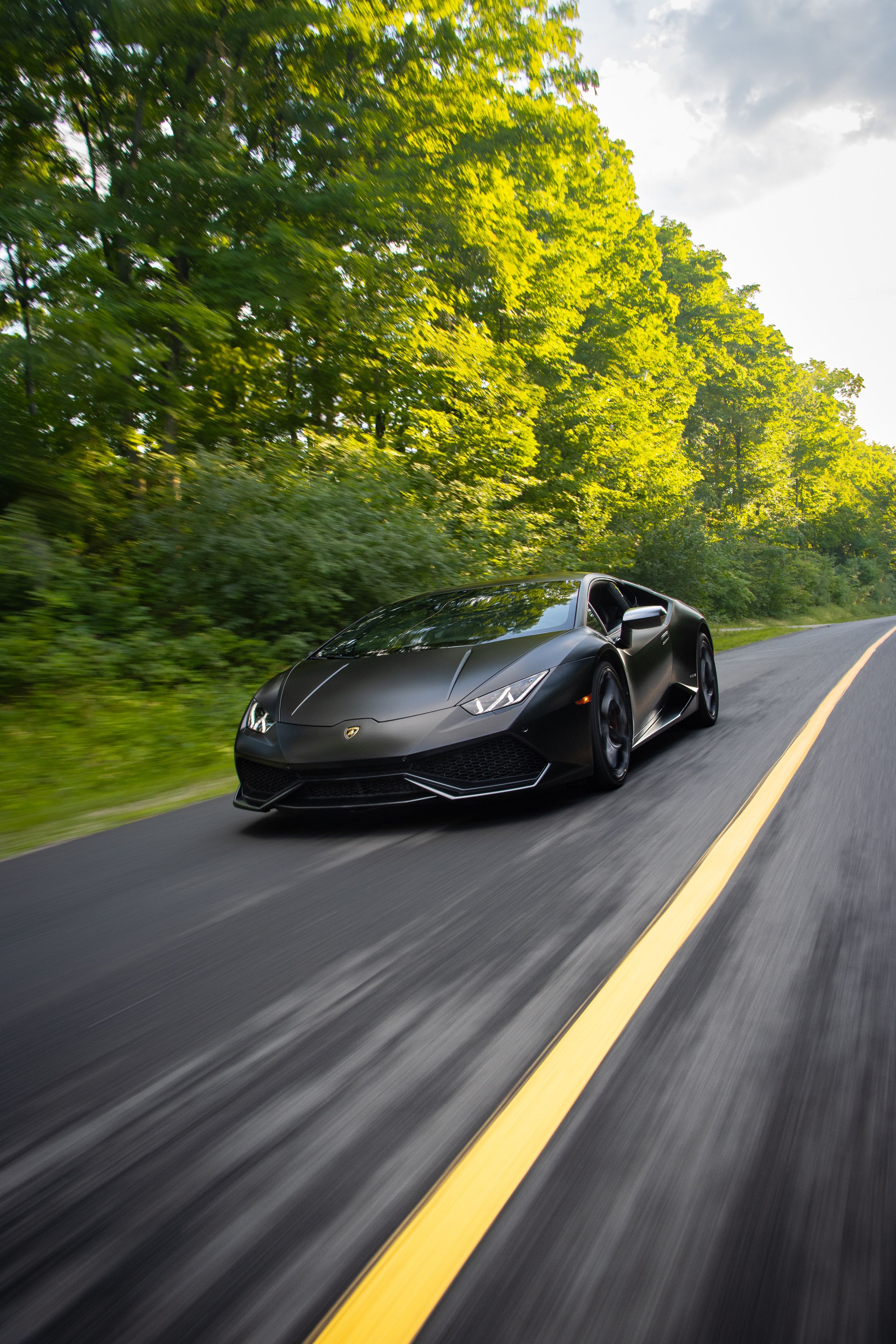 Black Sports Car and a Road with a Yellow Line · Free Stock Photo