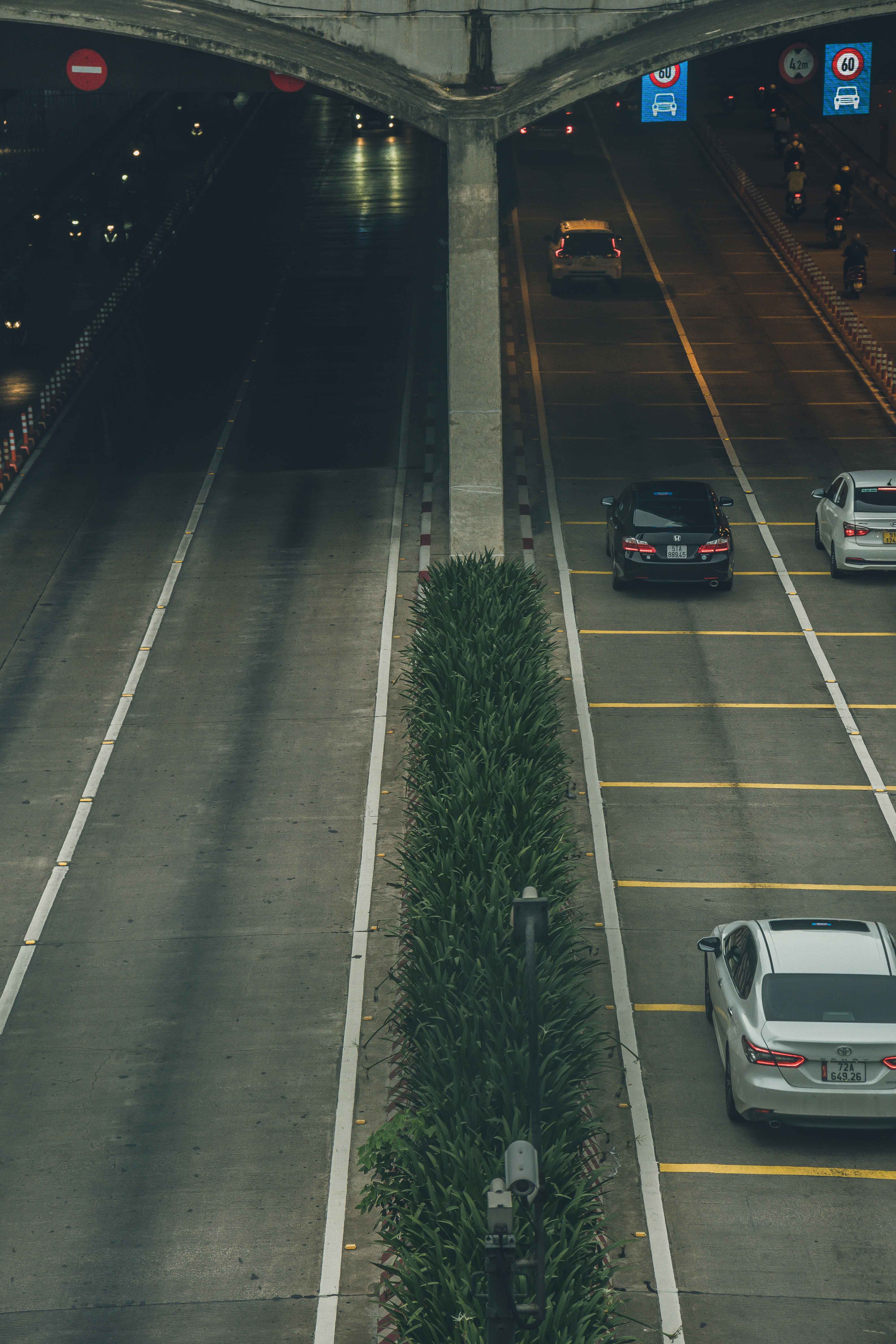 Cars driving under a bridge · Free Stock Photo