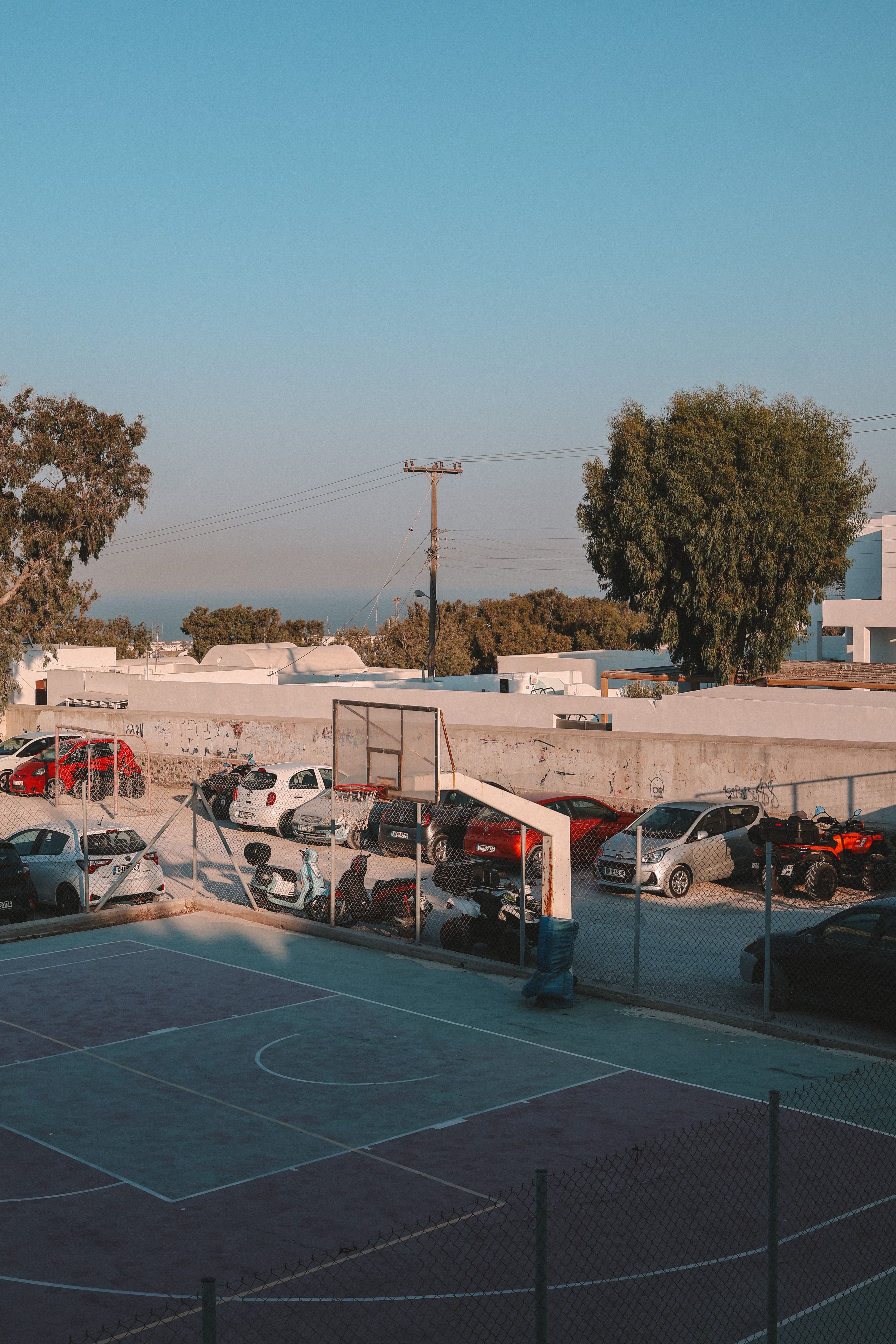 A basketball court with cars parked in front of it · Free Stock Photo