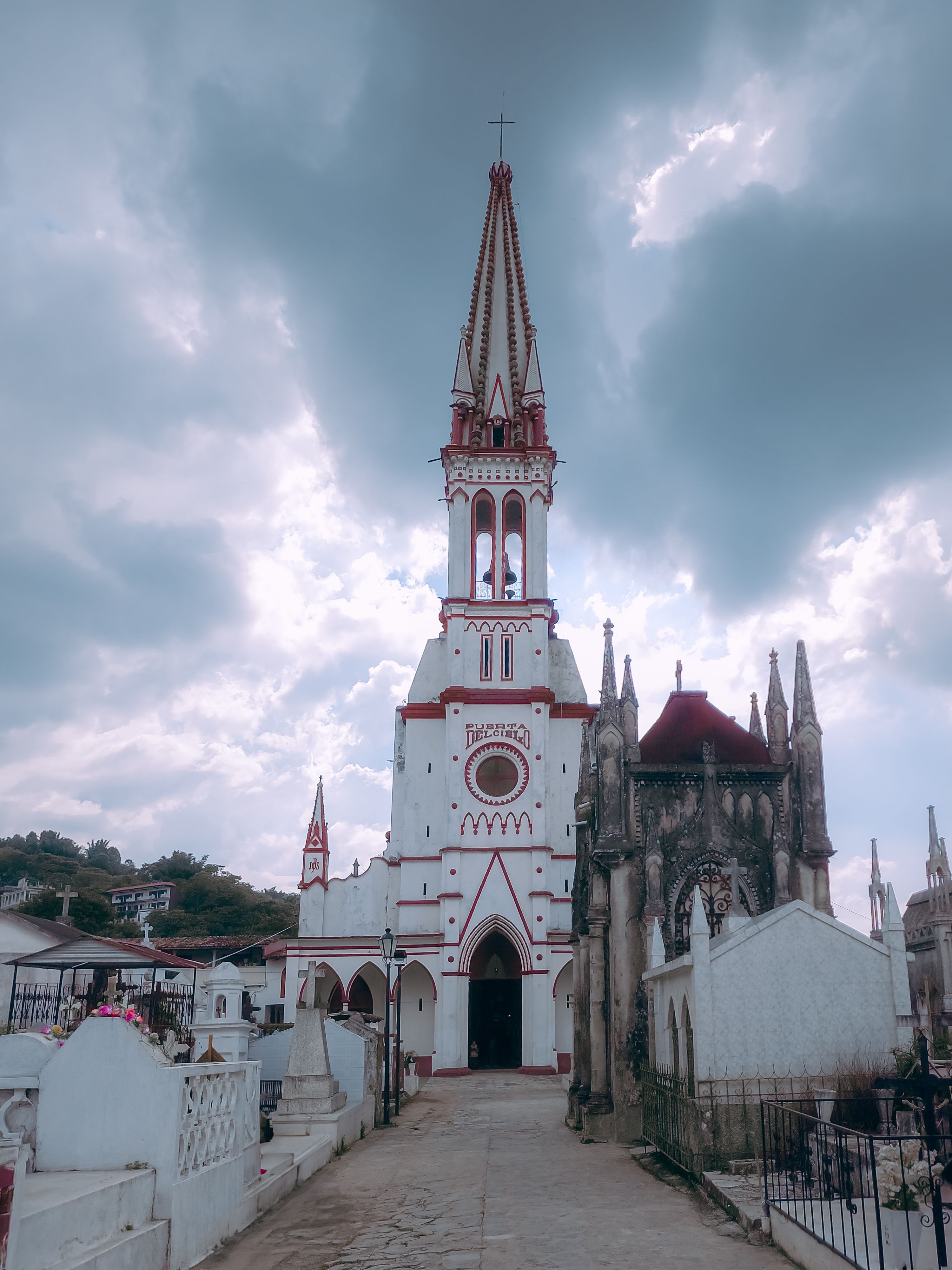 A church with a steeple and a cemetery behind it · Free Stock Photo