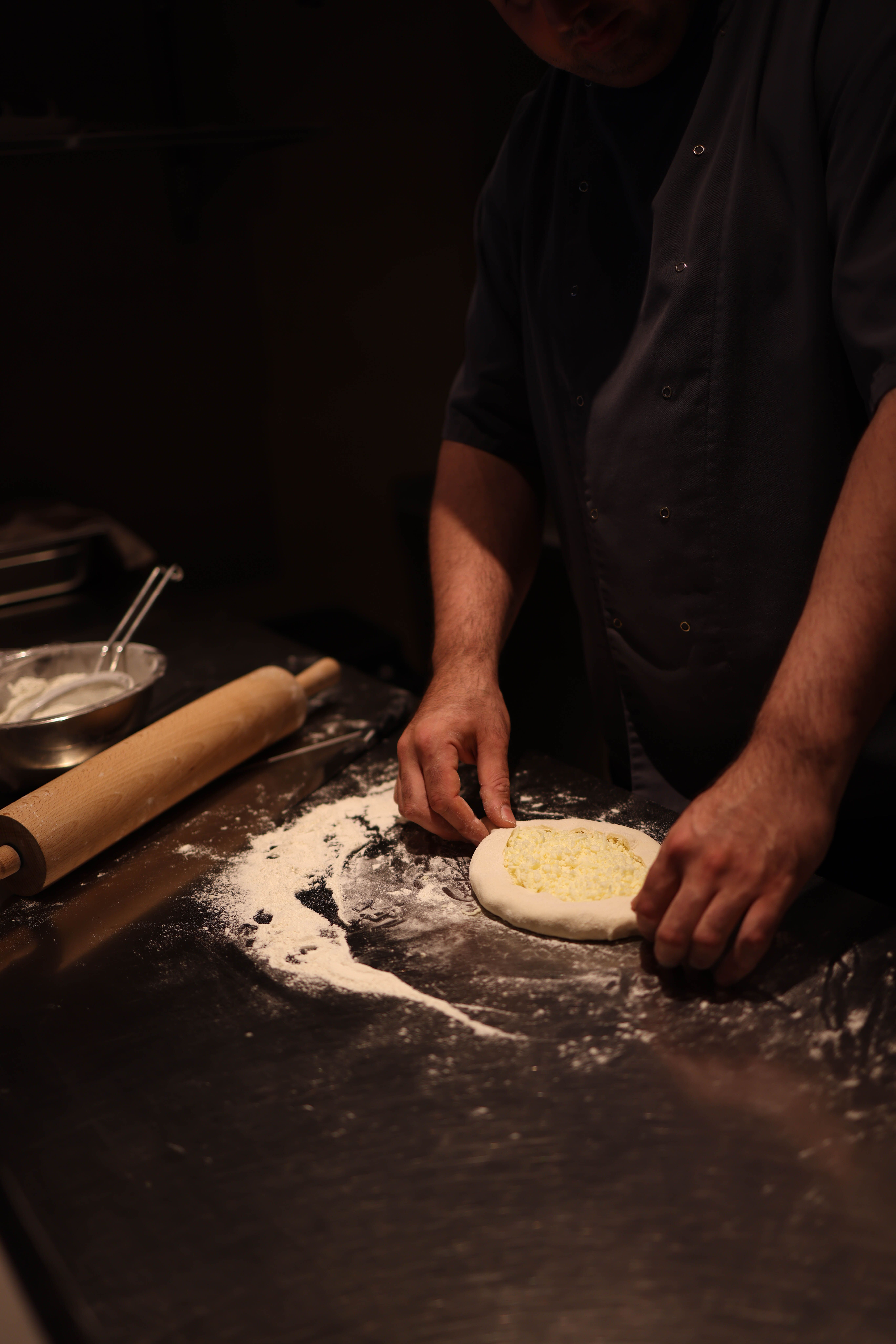 A chef is making dough on a table · Free Stock Photo