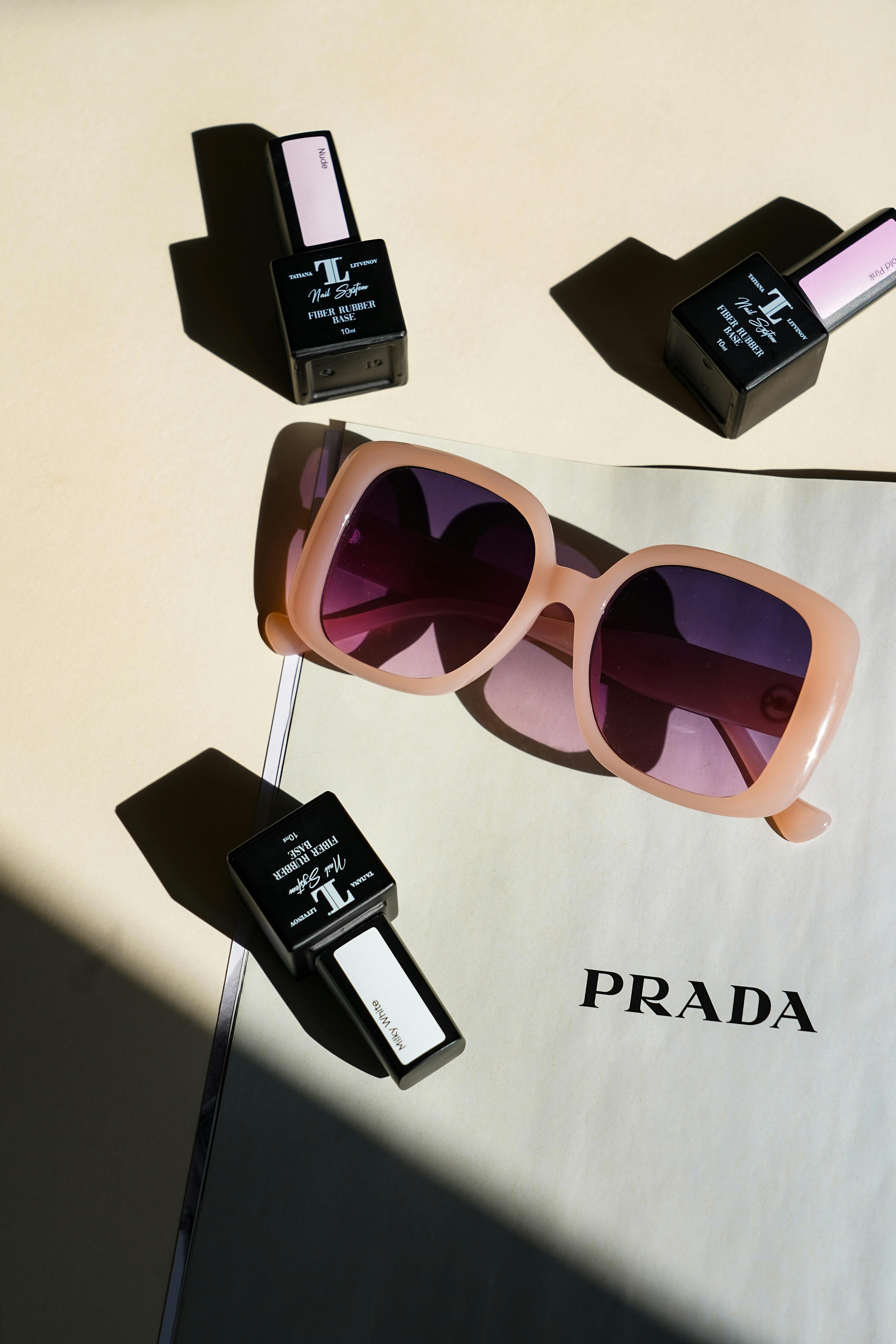 Prada sunglasses and a book with the words prada on it · Free Stock Photo