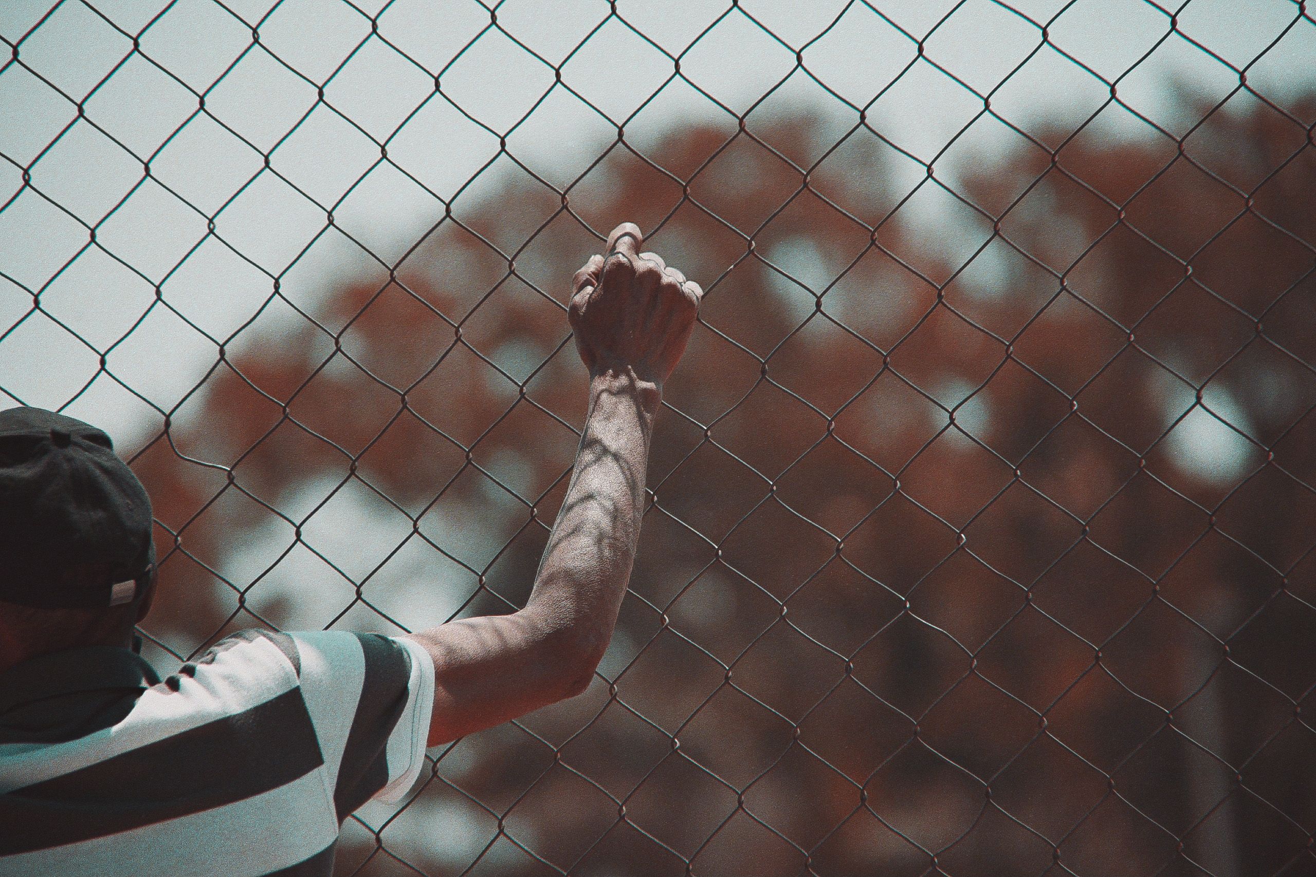 Back View of a Man Standing by the Fence · Free Stock Photo