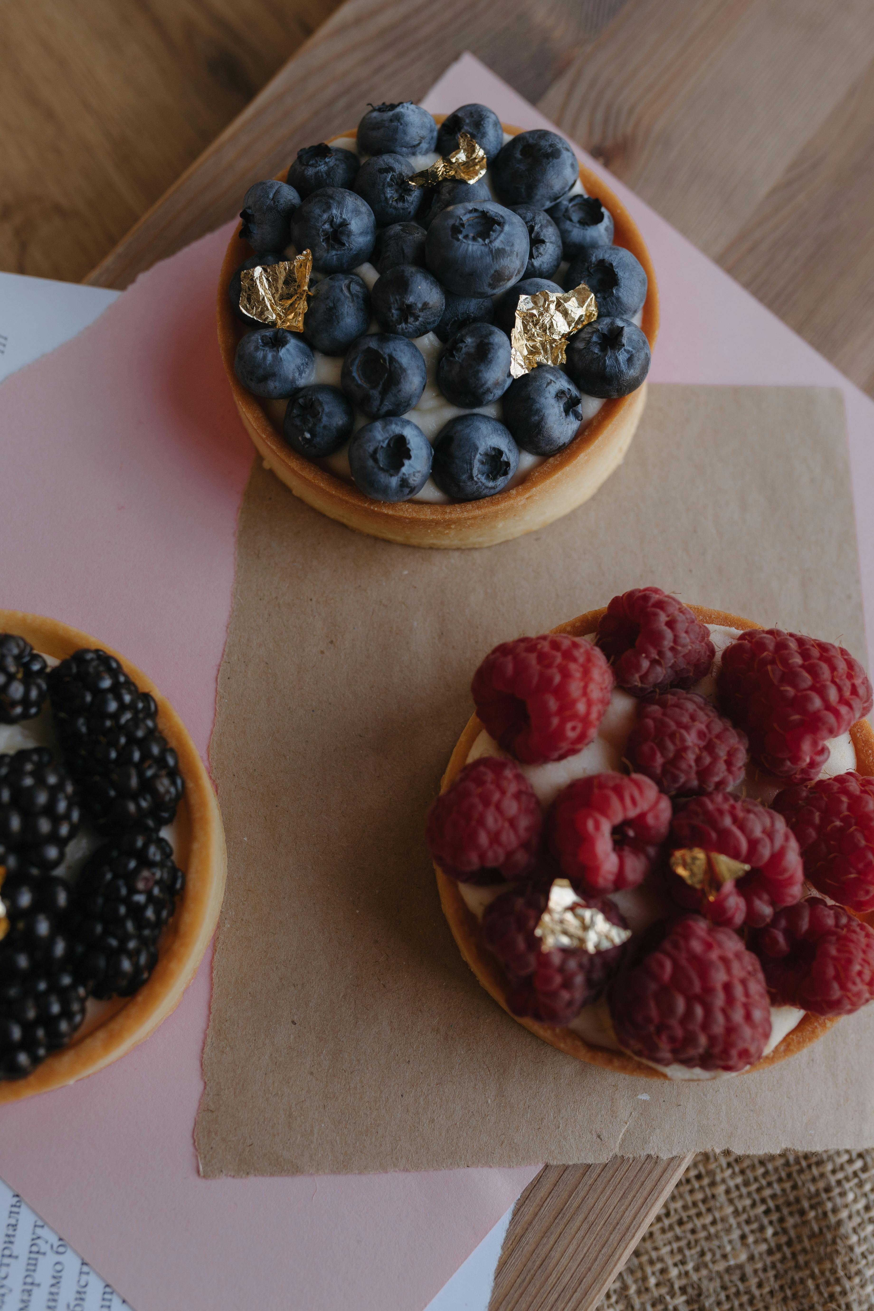 Three different types of pastries with berries on top · Free Stock Photo