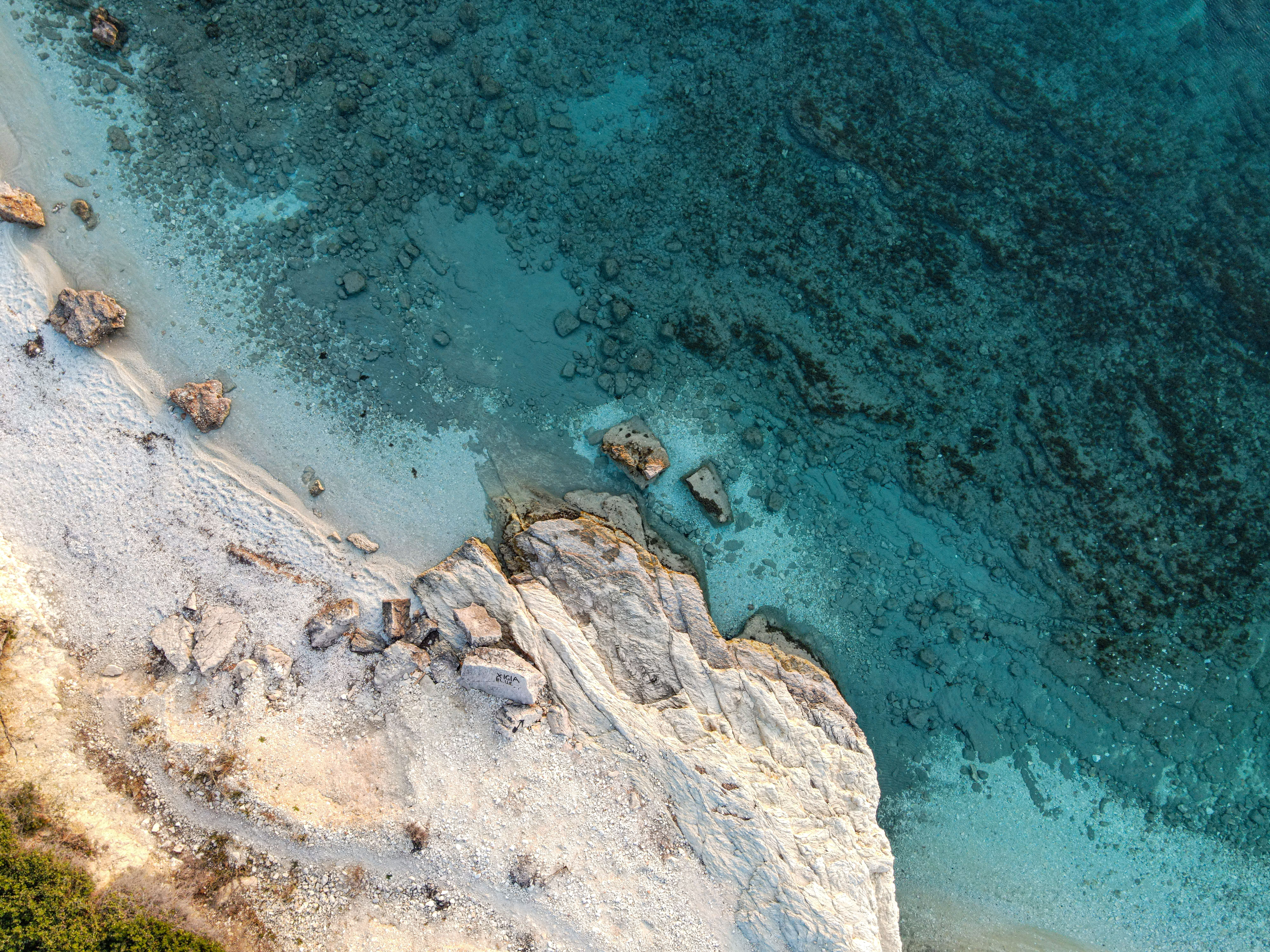 Aerial view of a beach with clear water and rocks · Free Stock Photo