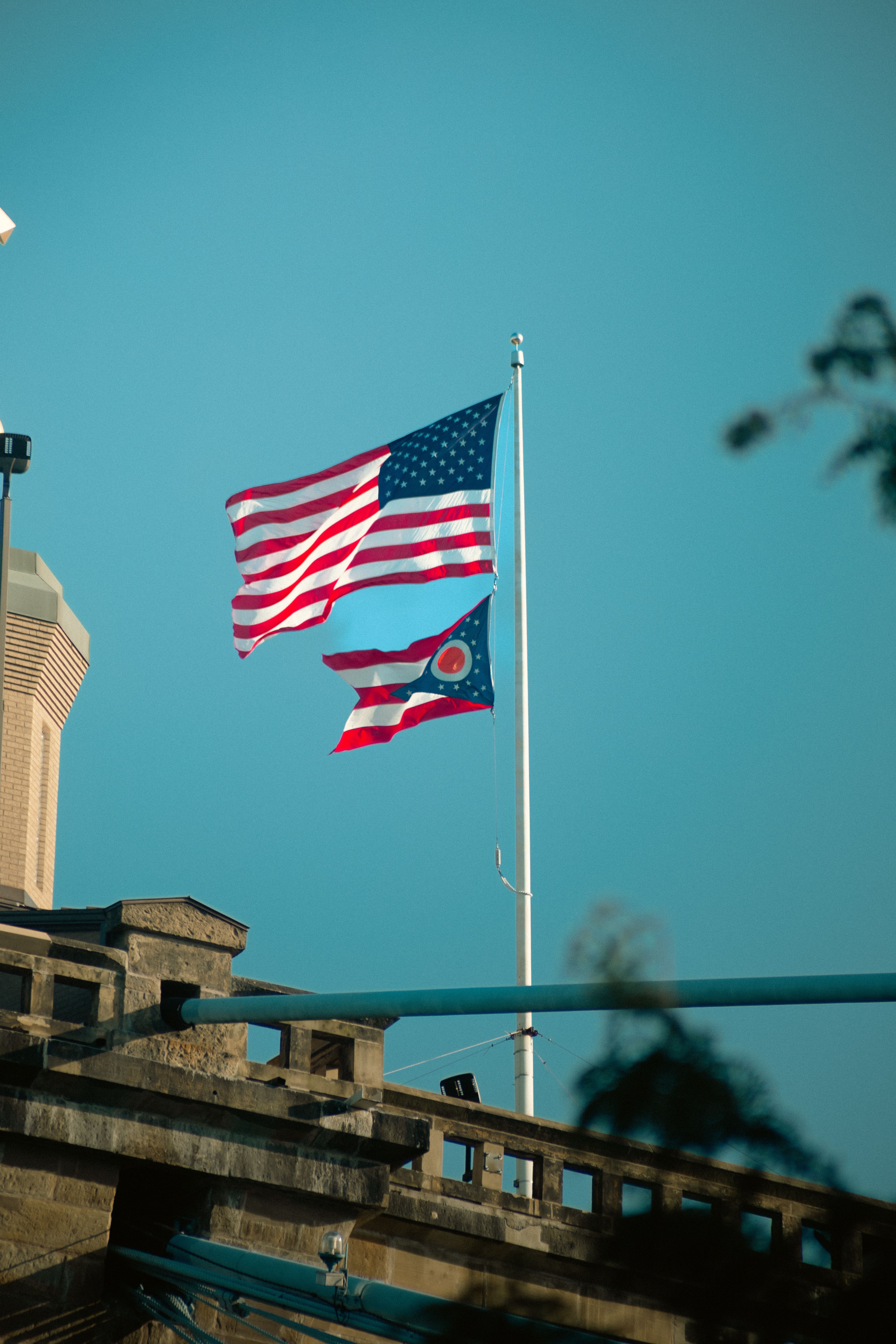 Two american flags flying in front of a building · Free Stock Photo
