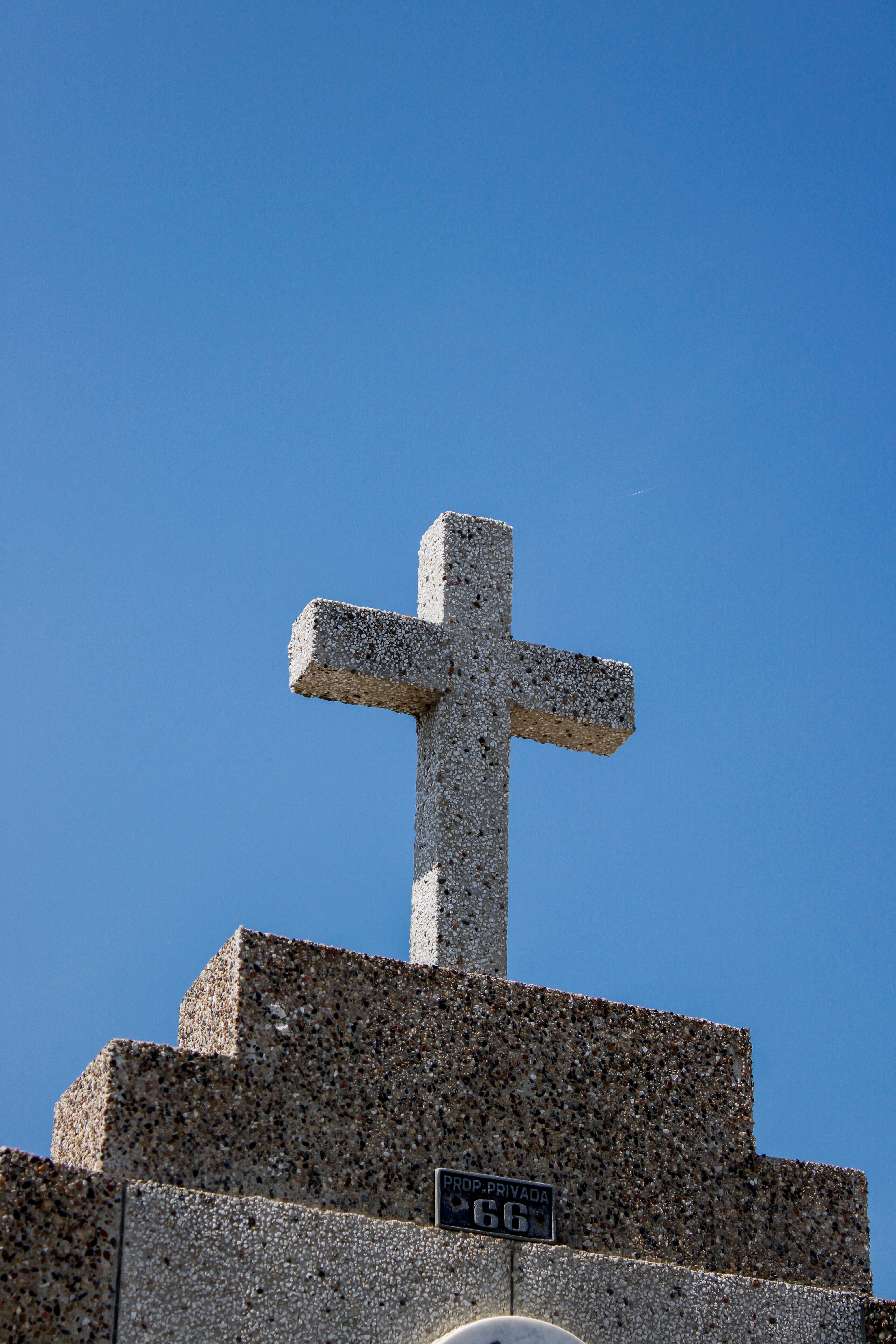 A cross on top of a stone monument · Free Stock Photo