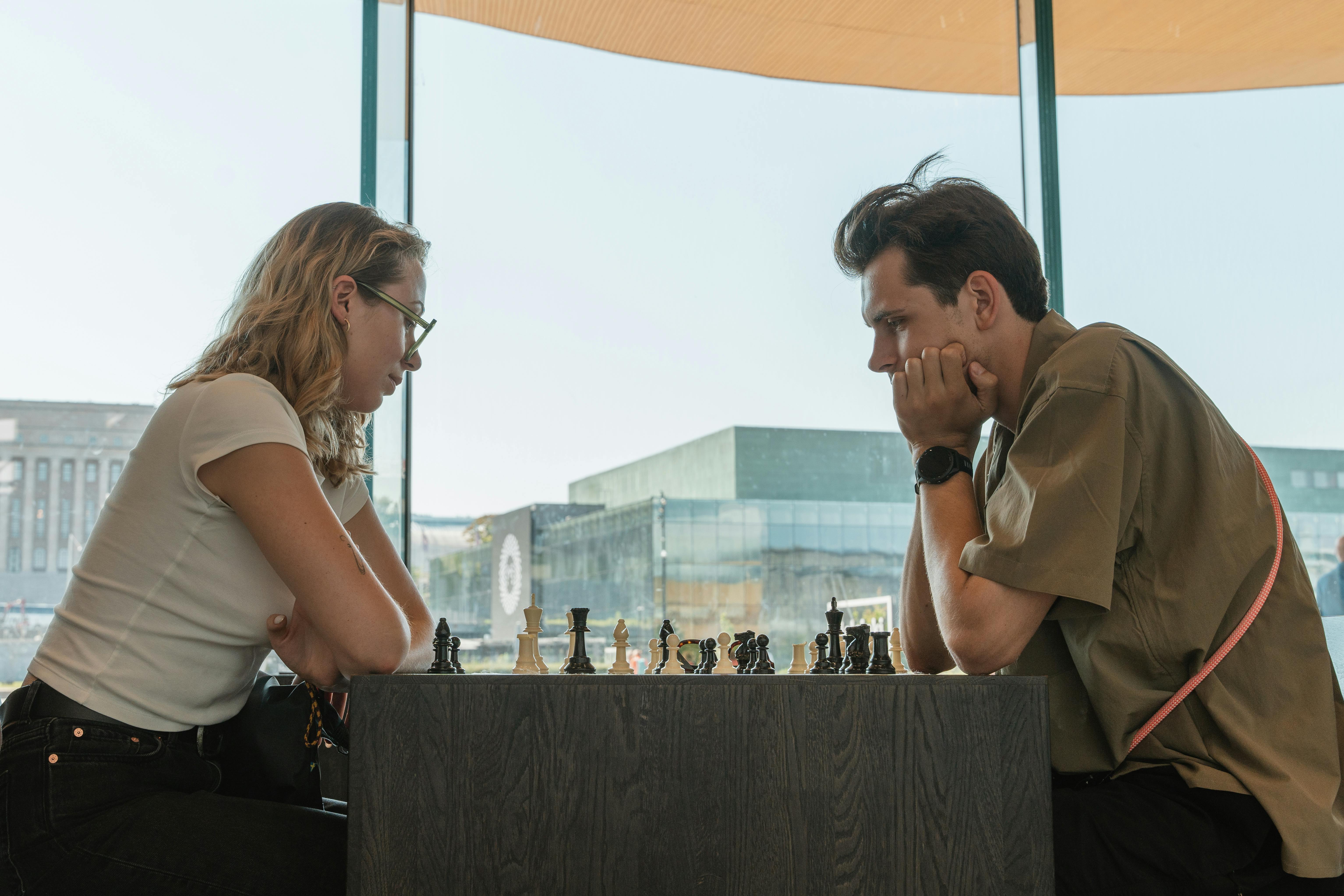 A beautiful couple plays chess games in the library. Photographed on ...