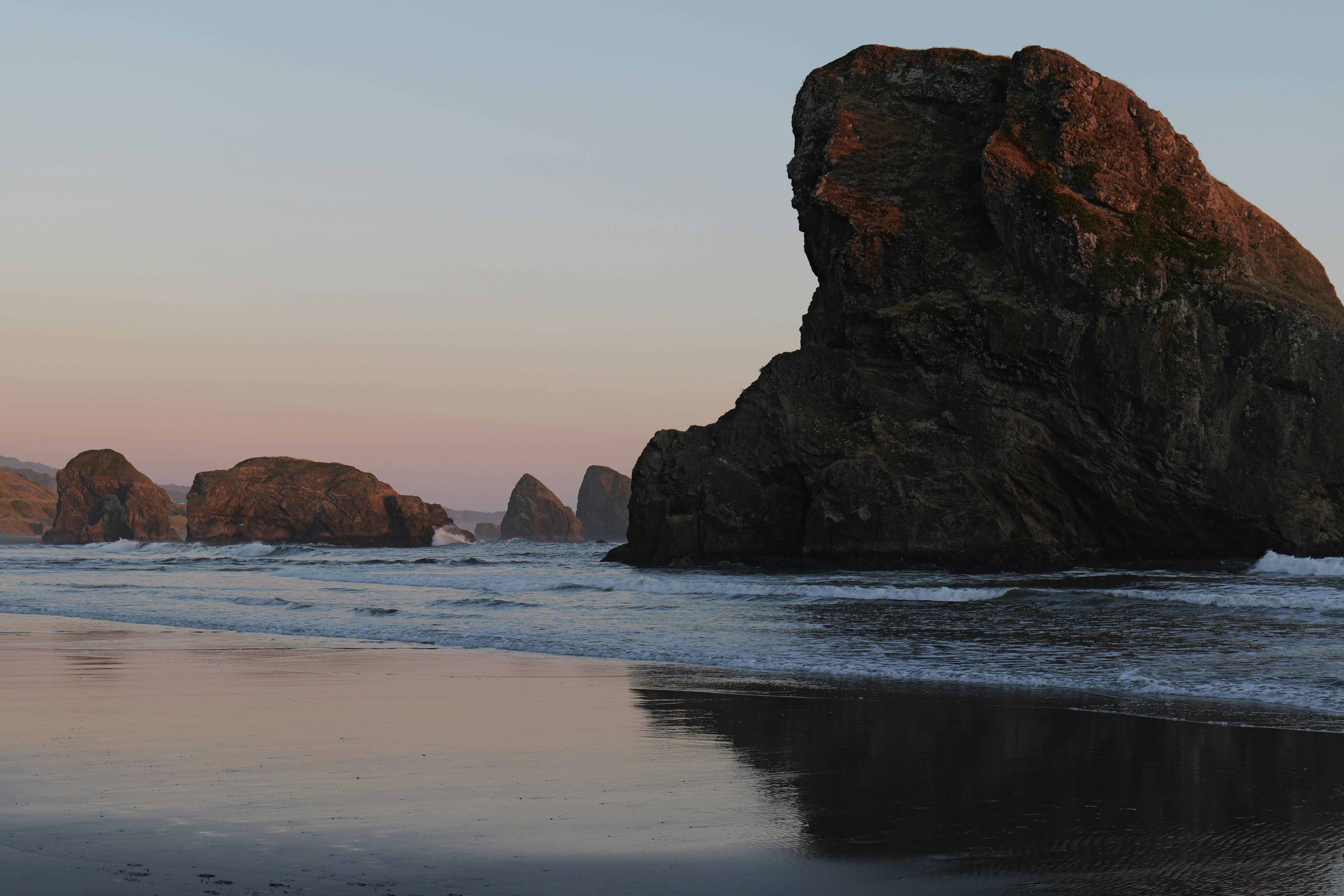 Brown and Gray Rocks on Seashore during Sunset · Free Stock Photo
