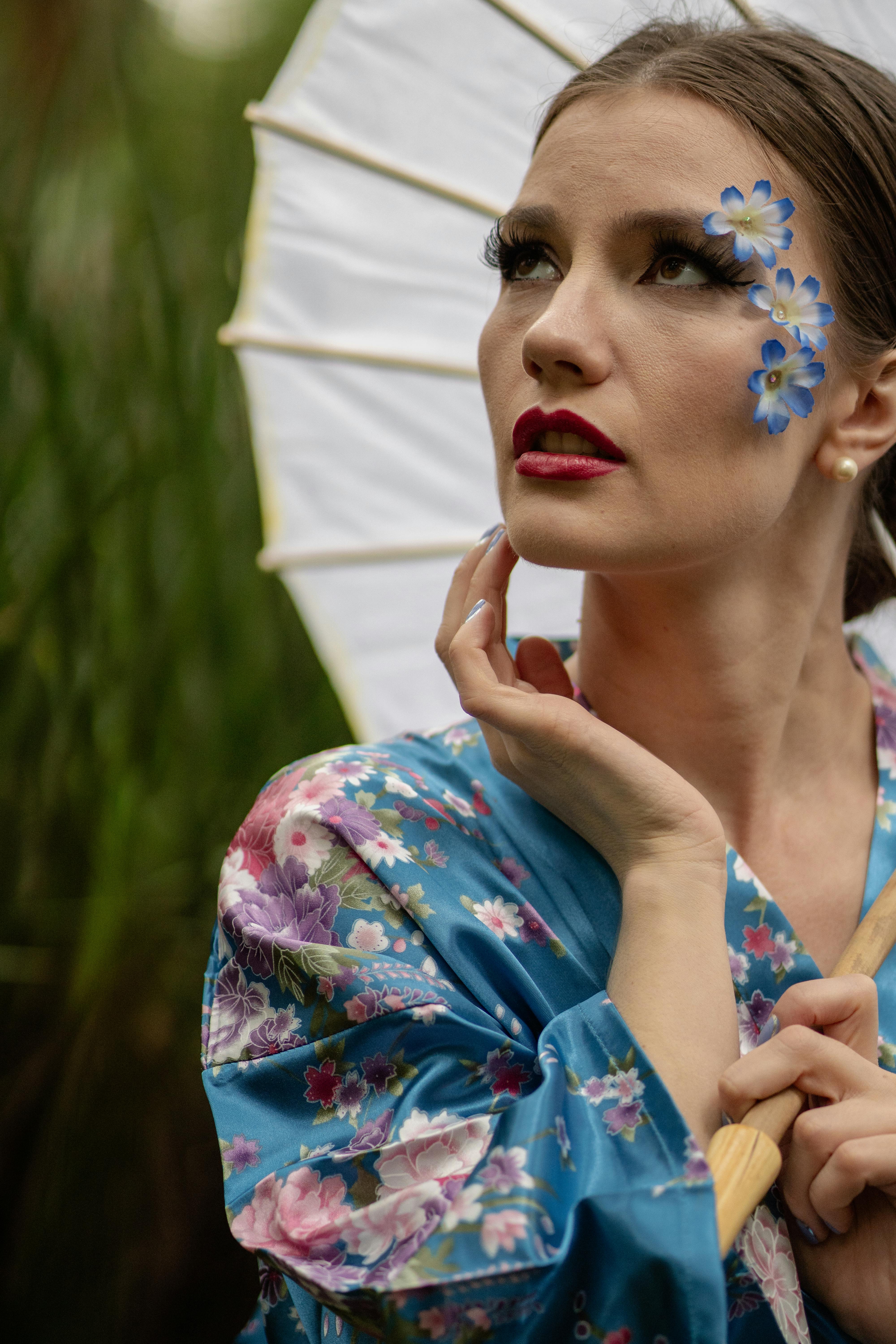 A woman with blue face paint and a white umbrella · Free Stock Photo