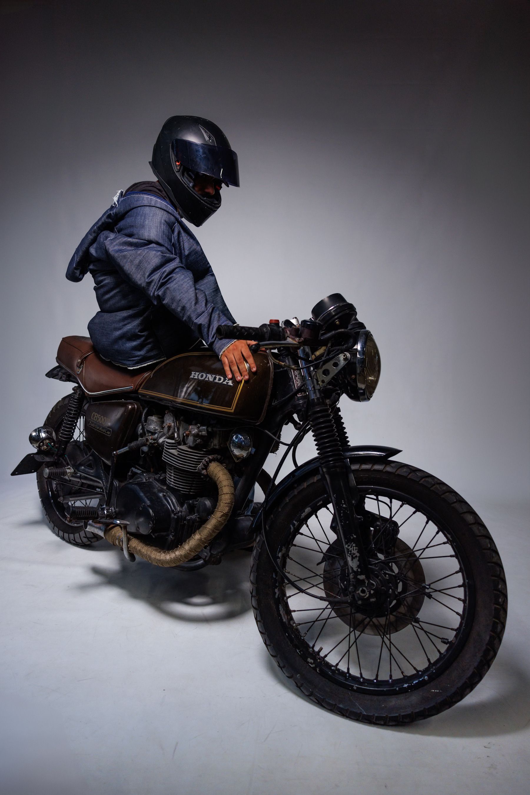 Studio Shot of a Biker in a Helmet on a Honda Motorcycle · Free Stock Photo