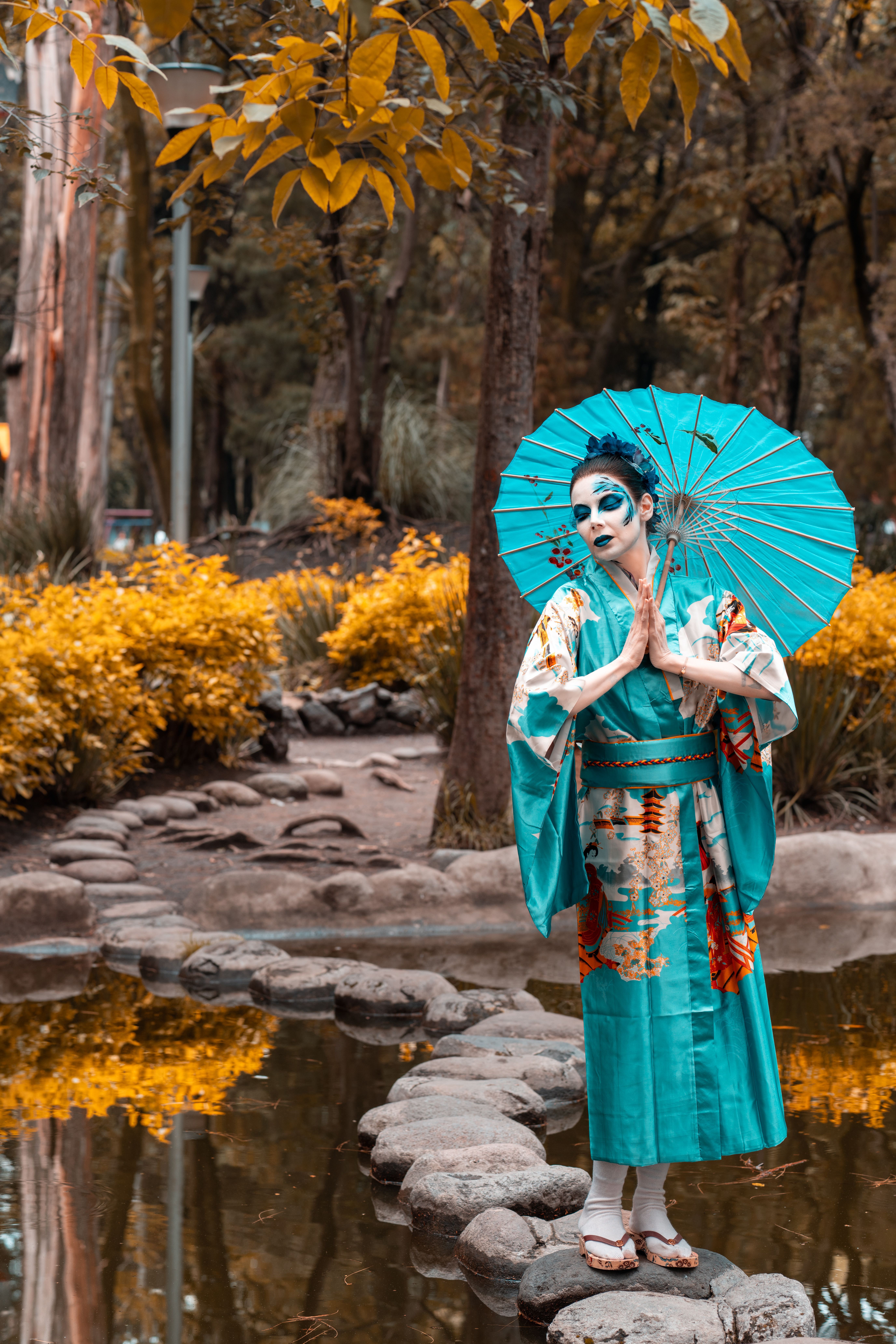Geisha in Traditional Clothing Standing on Stones on Lake at Park ...