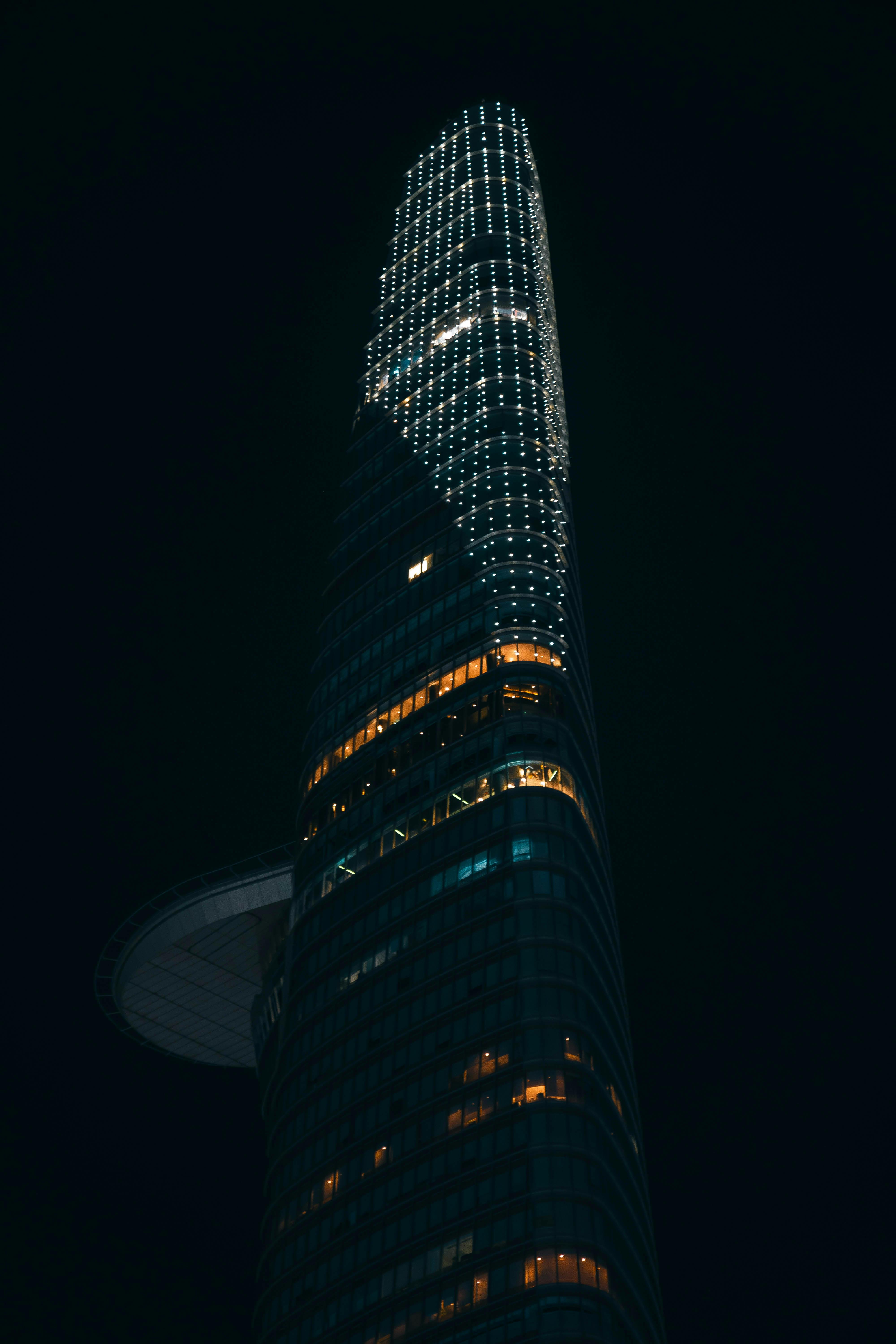 A tall building with lights on at night · Free Stock Photo