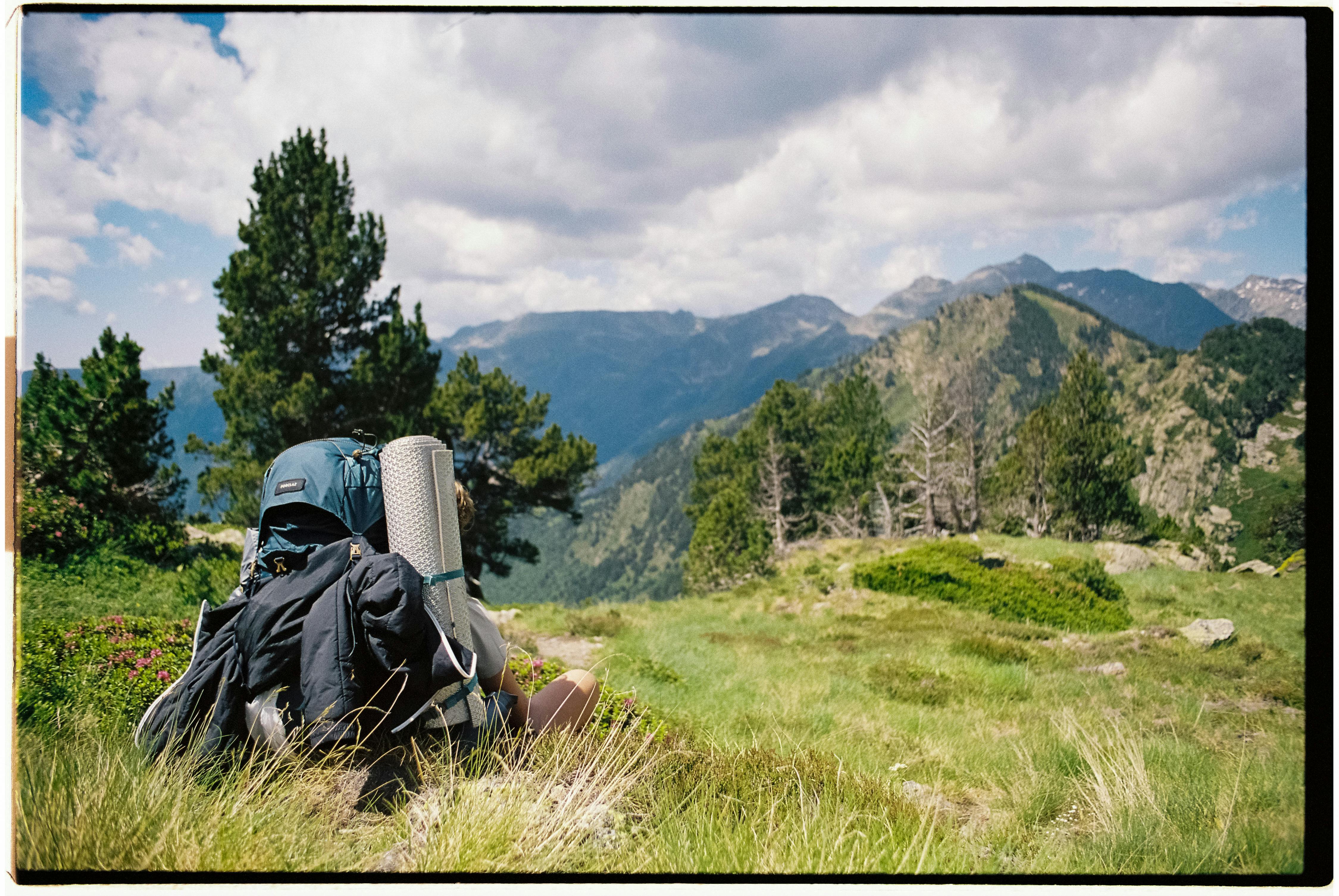 Hiker with an Expedition Backpack Sitting on a Meadow in the Mountains ...
