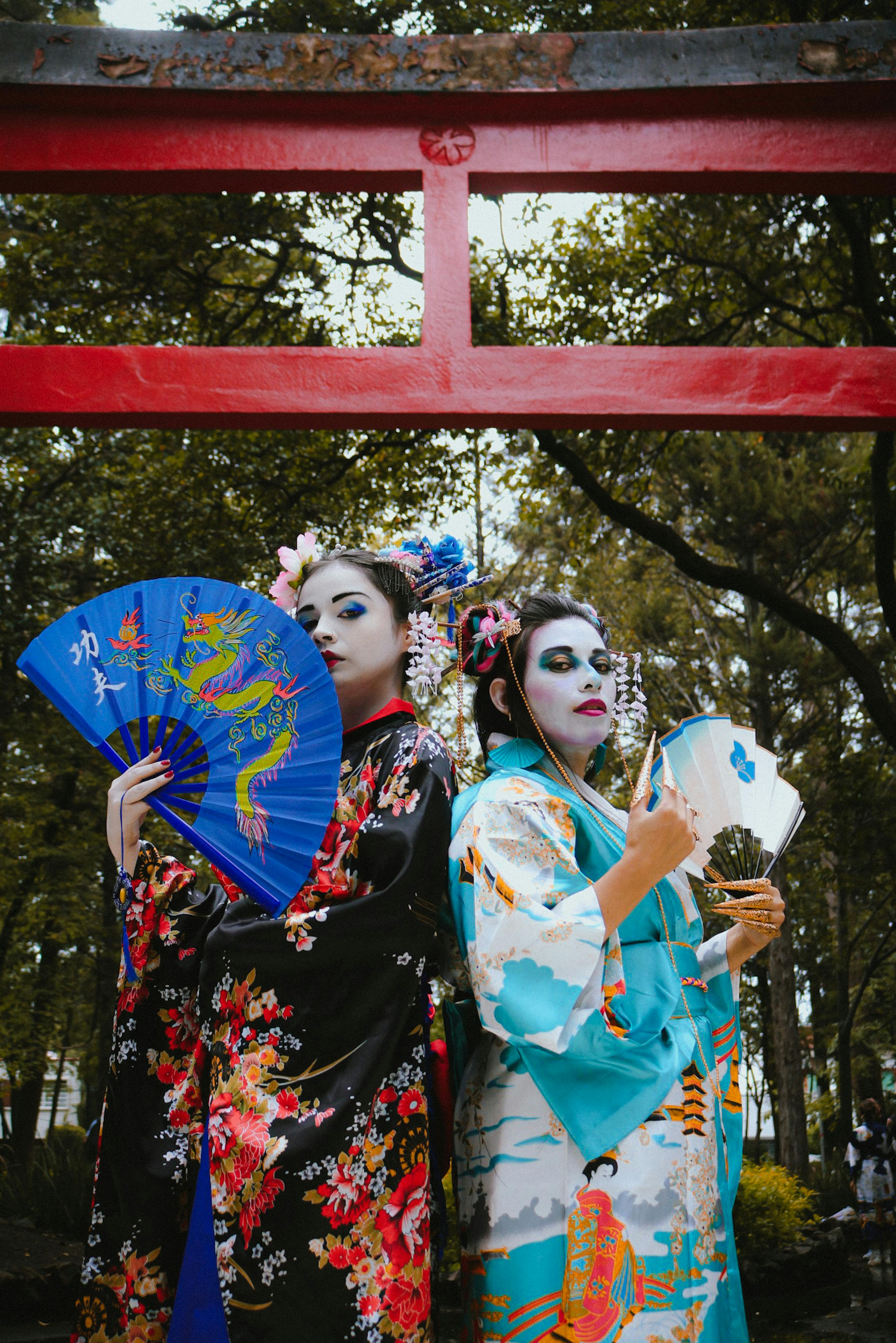Two women dressed in geisha costumes holding fans · Free Stock Photo