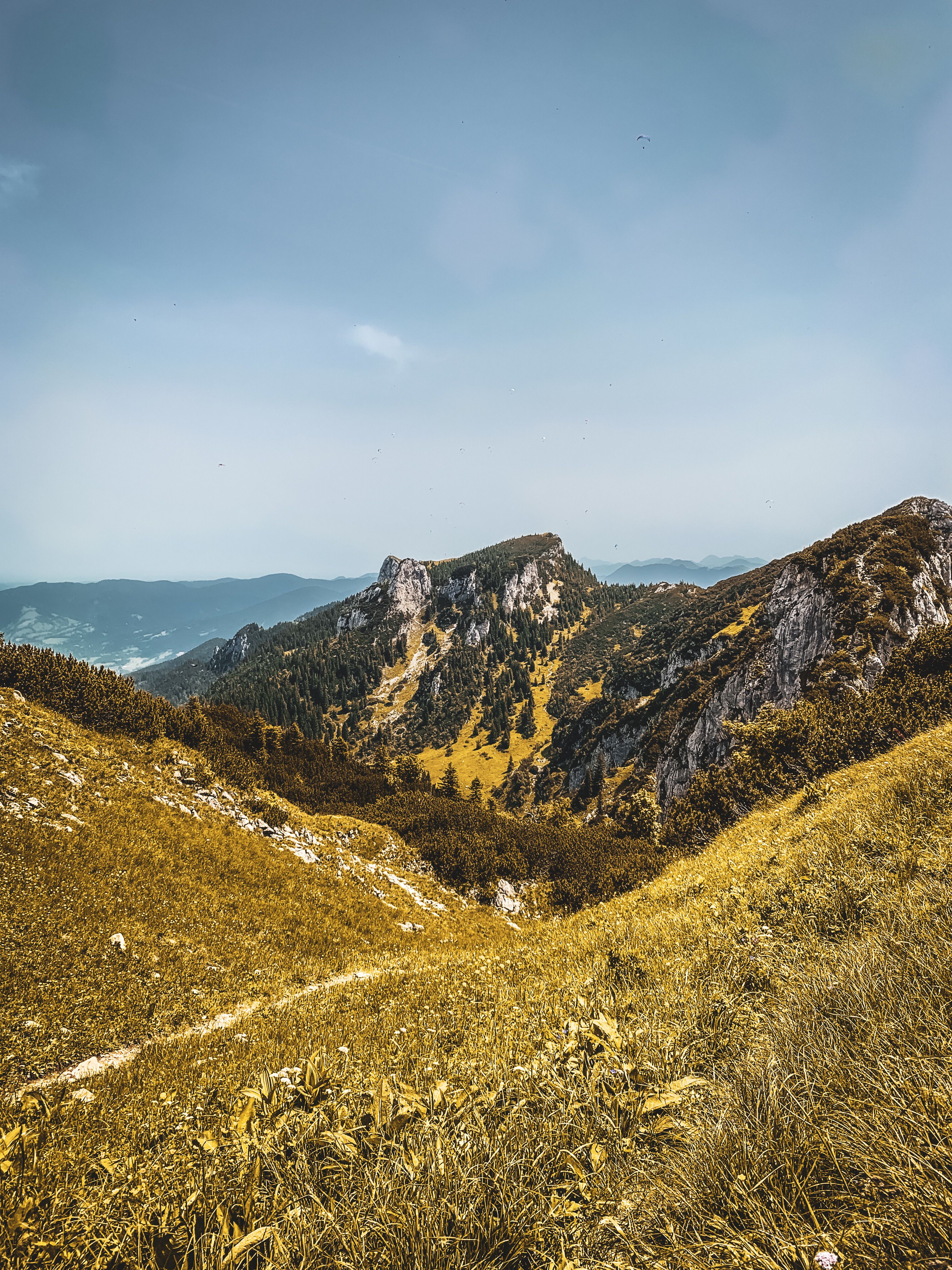 A mountain with grass and hills in the distance · Free Stock Photo
