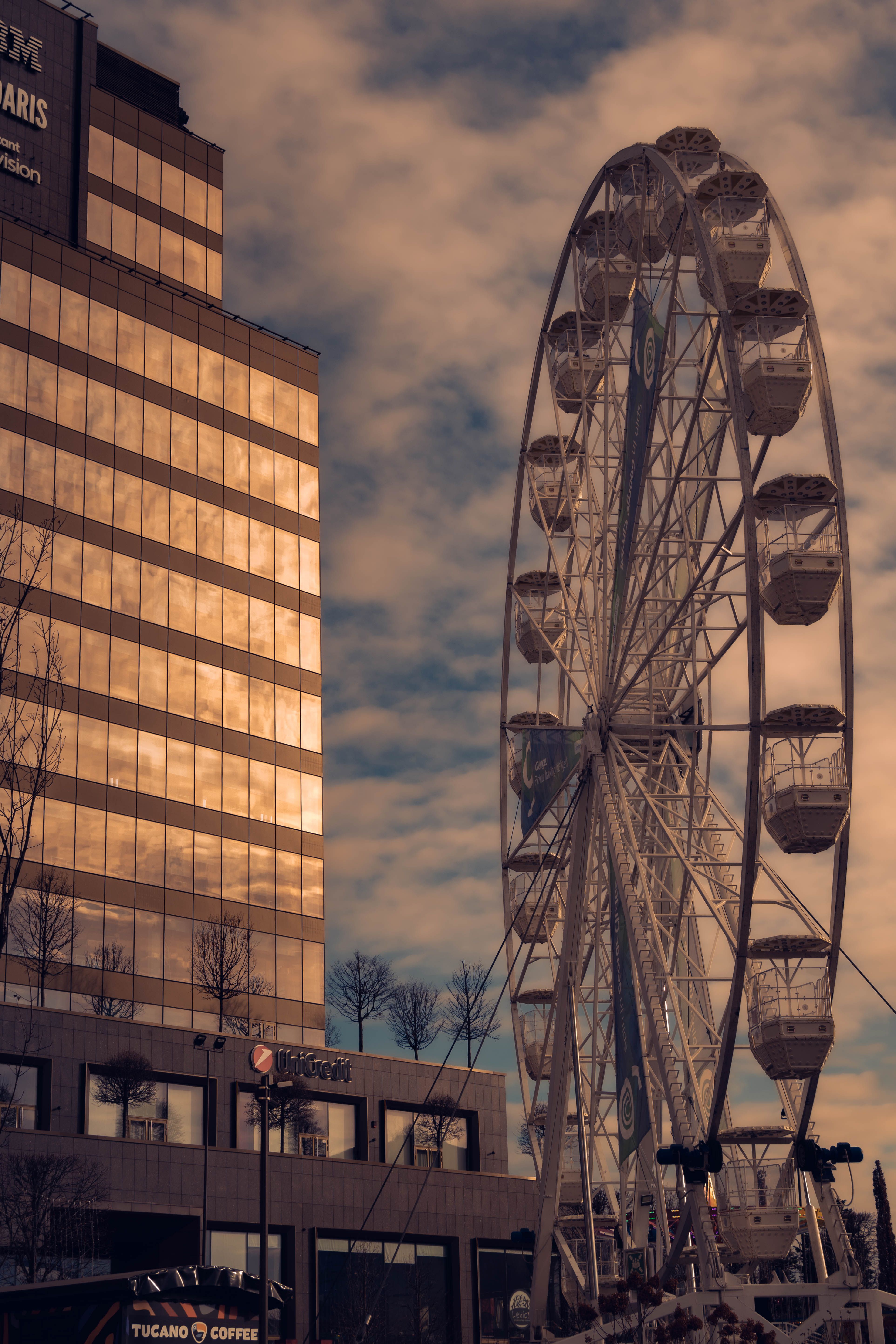 Ferris Wheel by the Modern Building in the Sunset · Free Stock Photo