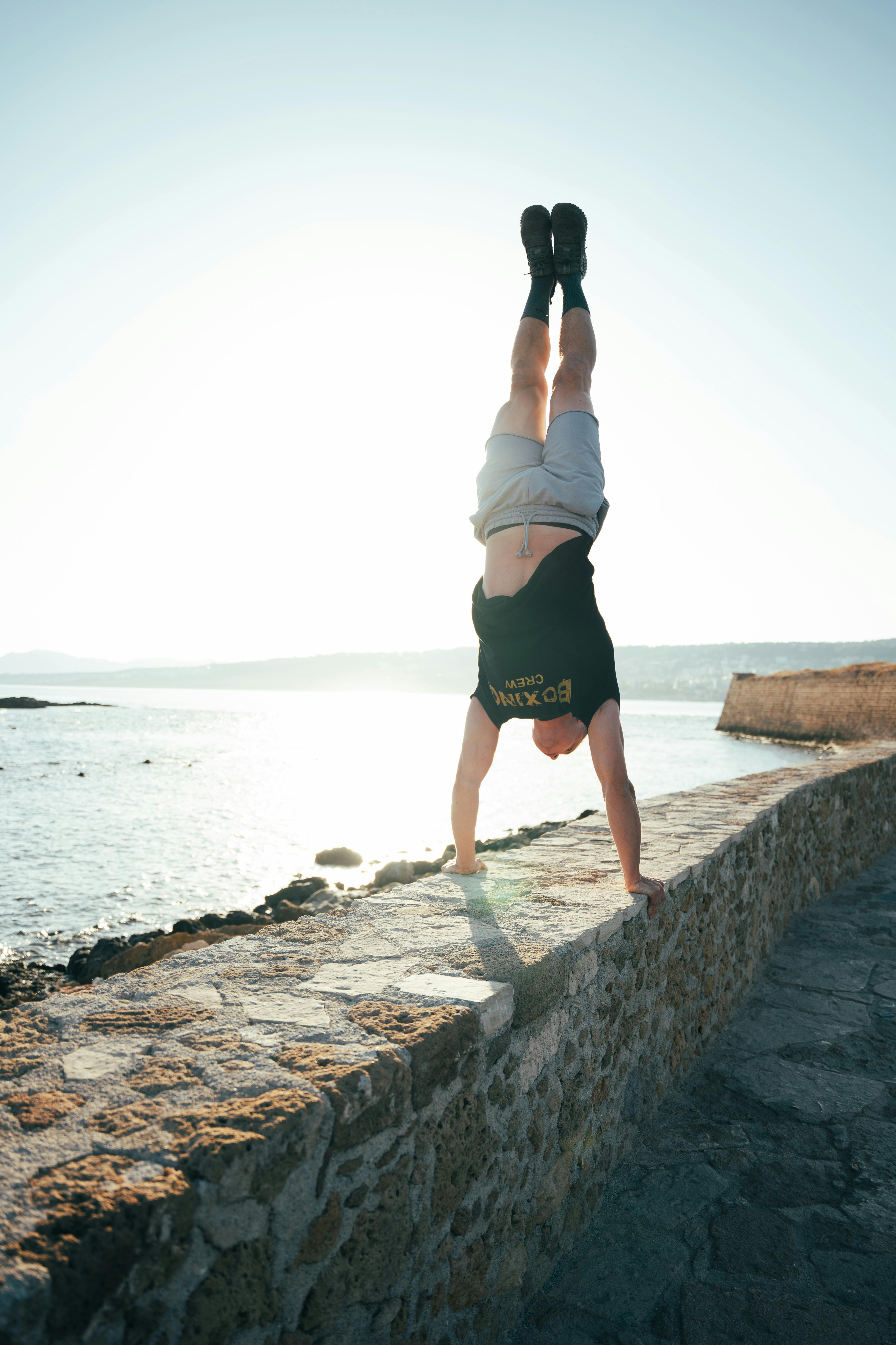 Man in Handstand on Wall at Sunset · Free Stock Photo