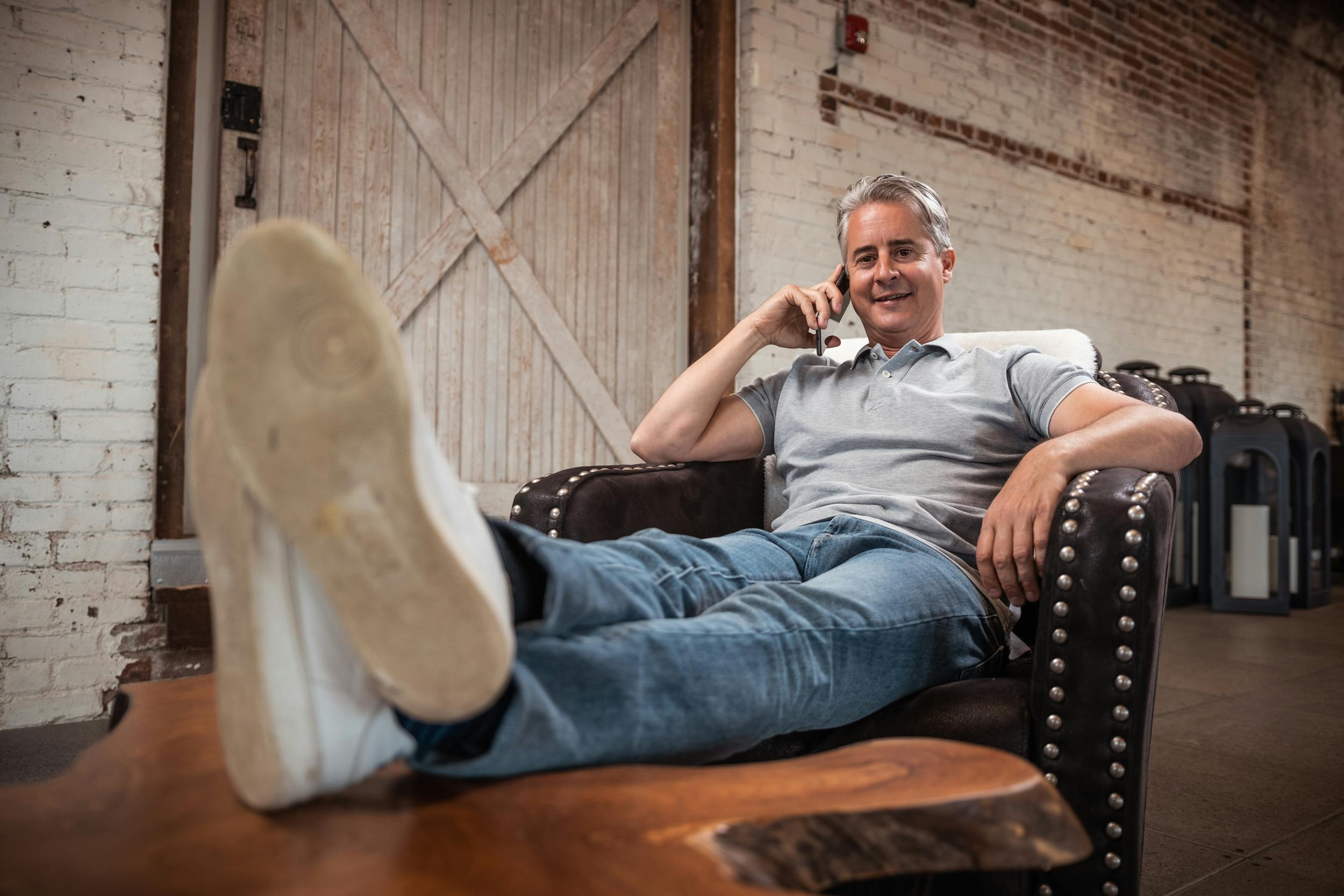 Man Holding Legs on Table · Free Stock Photo
