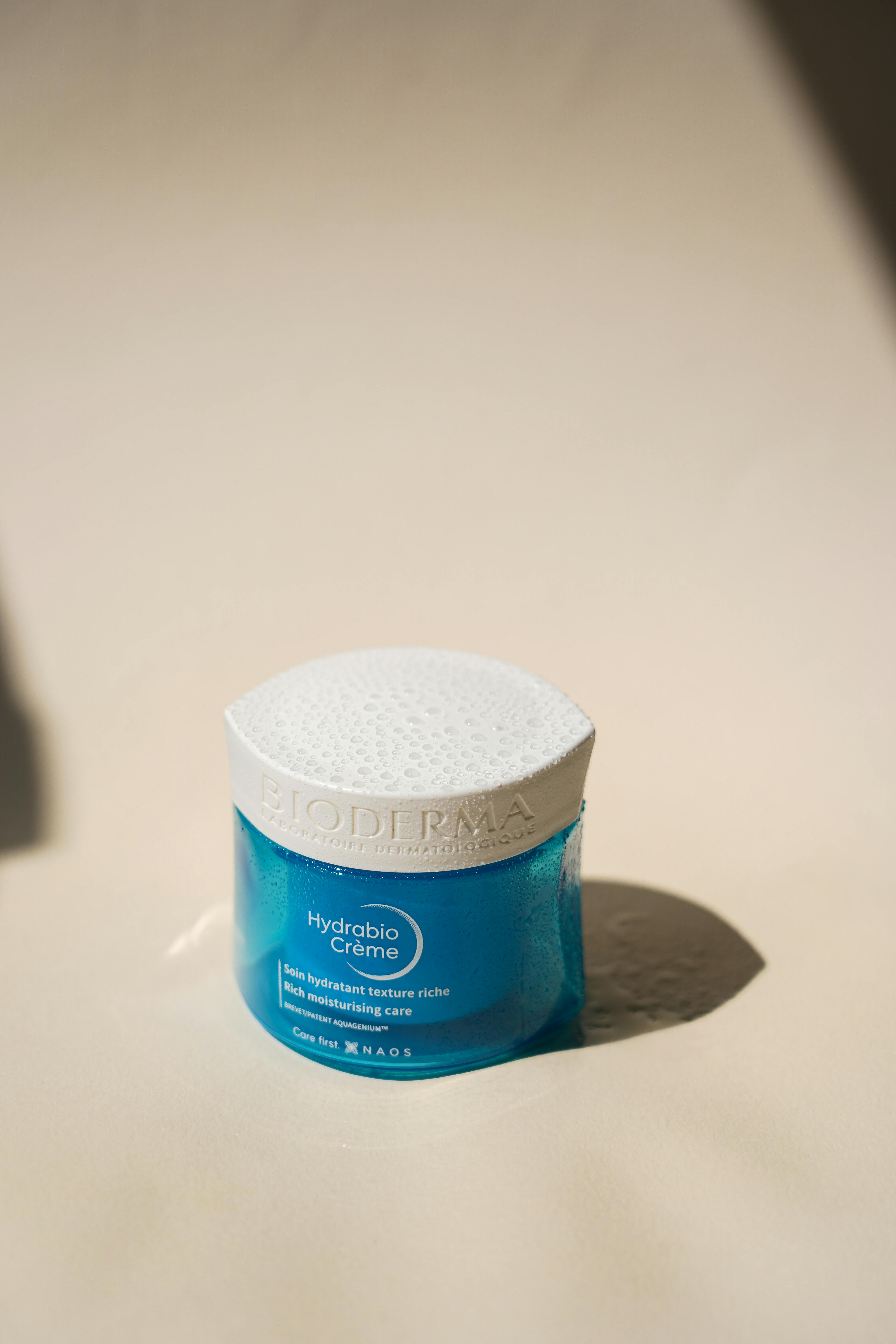 A jar of blue and white body cream · Free Stock Photo