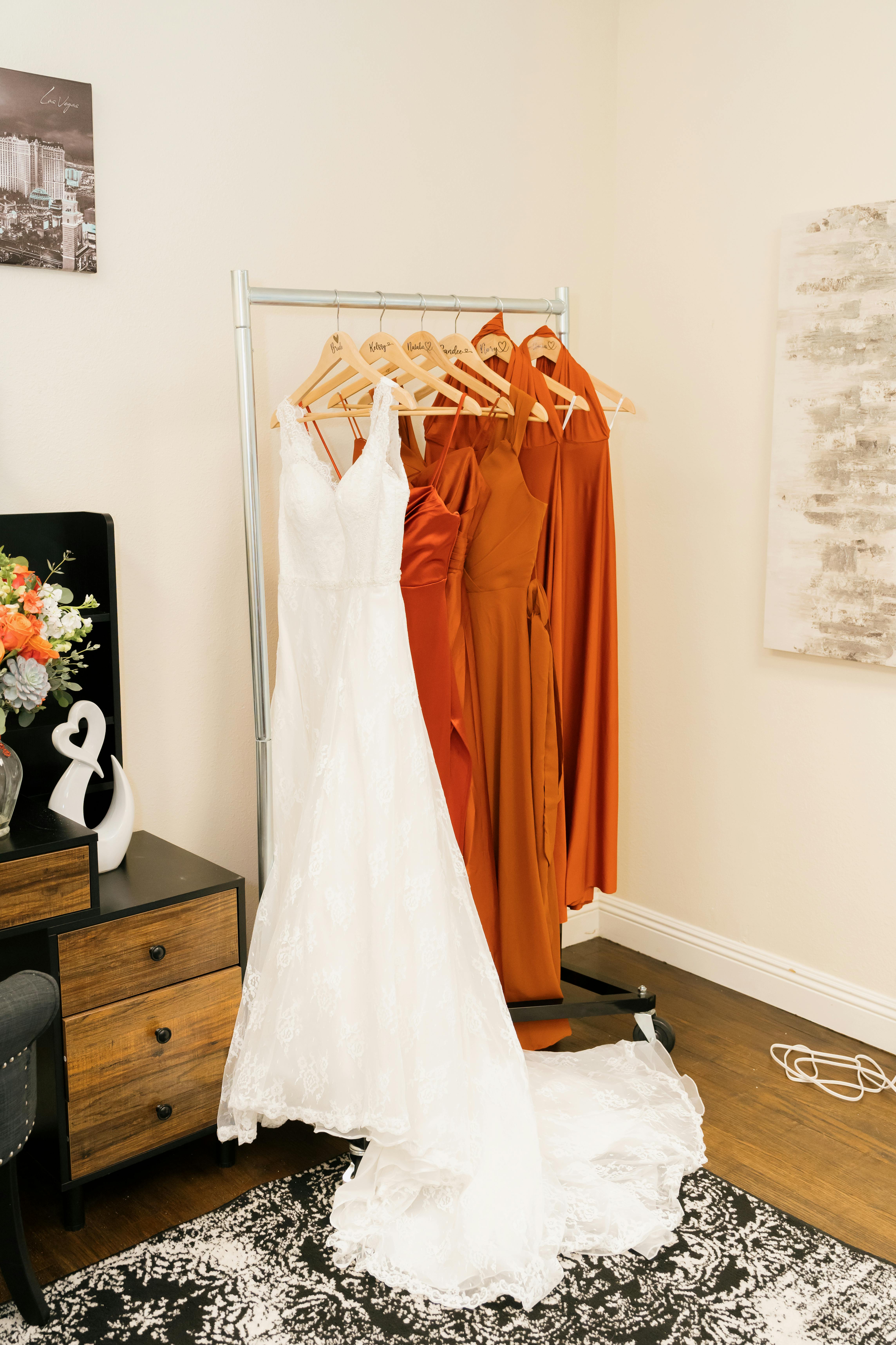 The Wedding Dress and Bridesmaids Dresses Hanging on a Clothing Rack ...