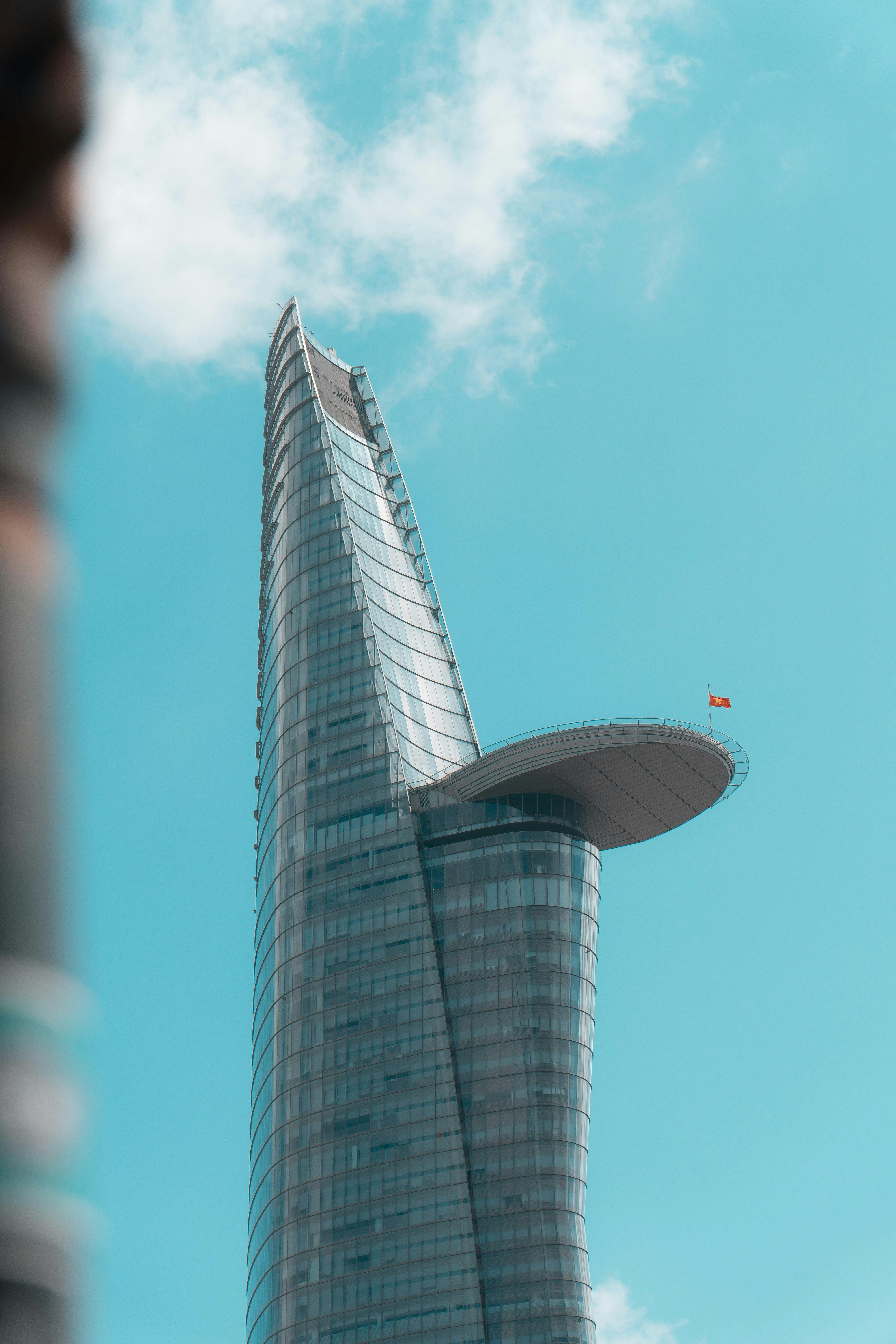 A tall building with a flag flying in the air · Free Stock Photo