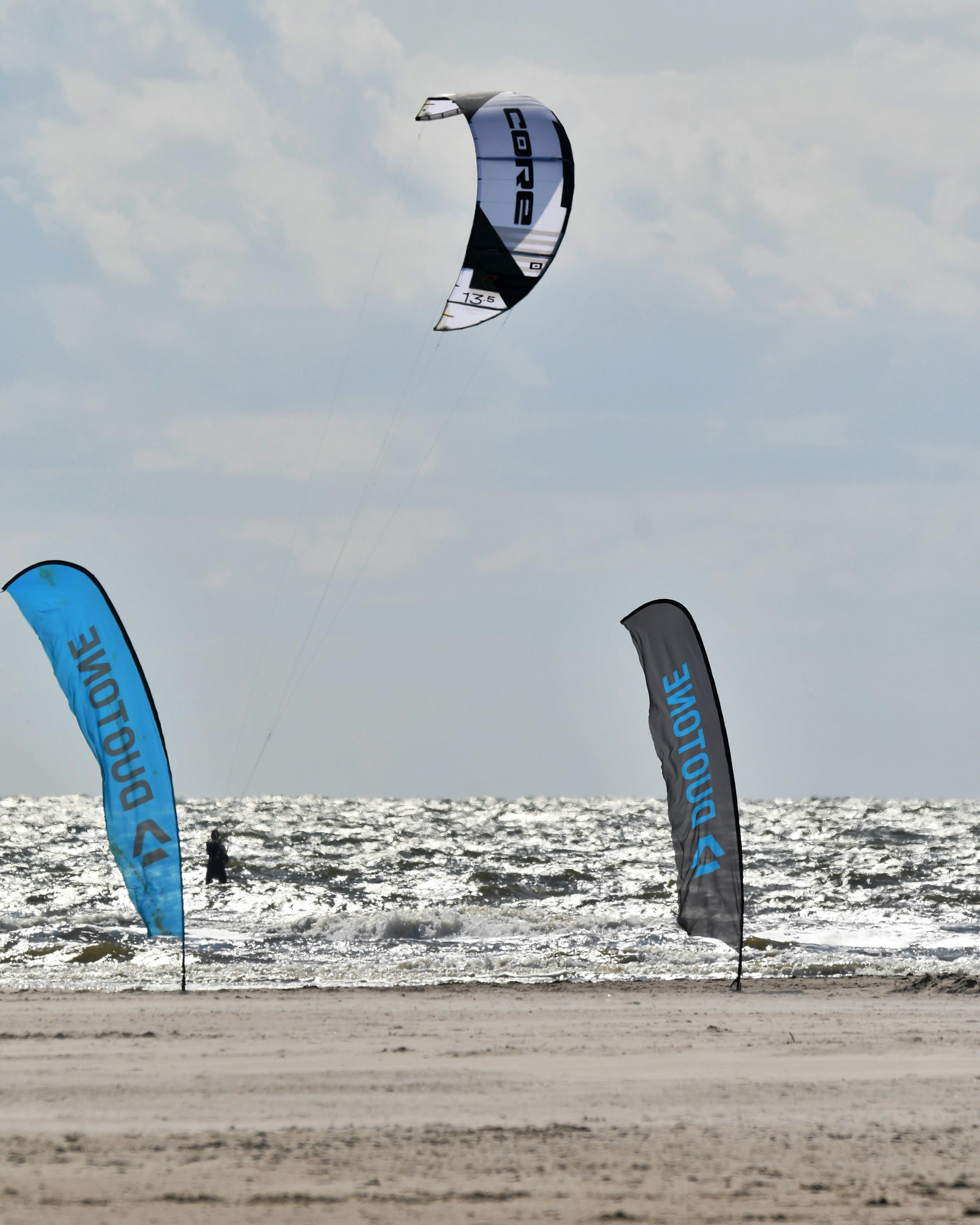 A kite surfer is flying over the ocean · Free Stock Photo