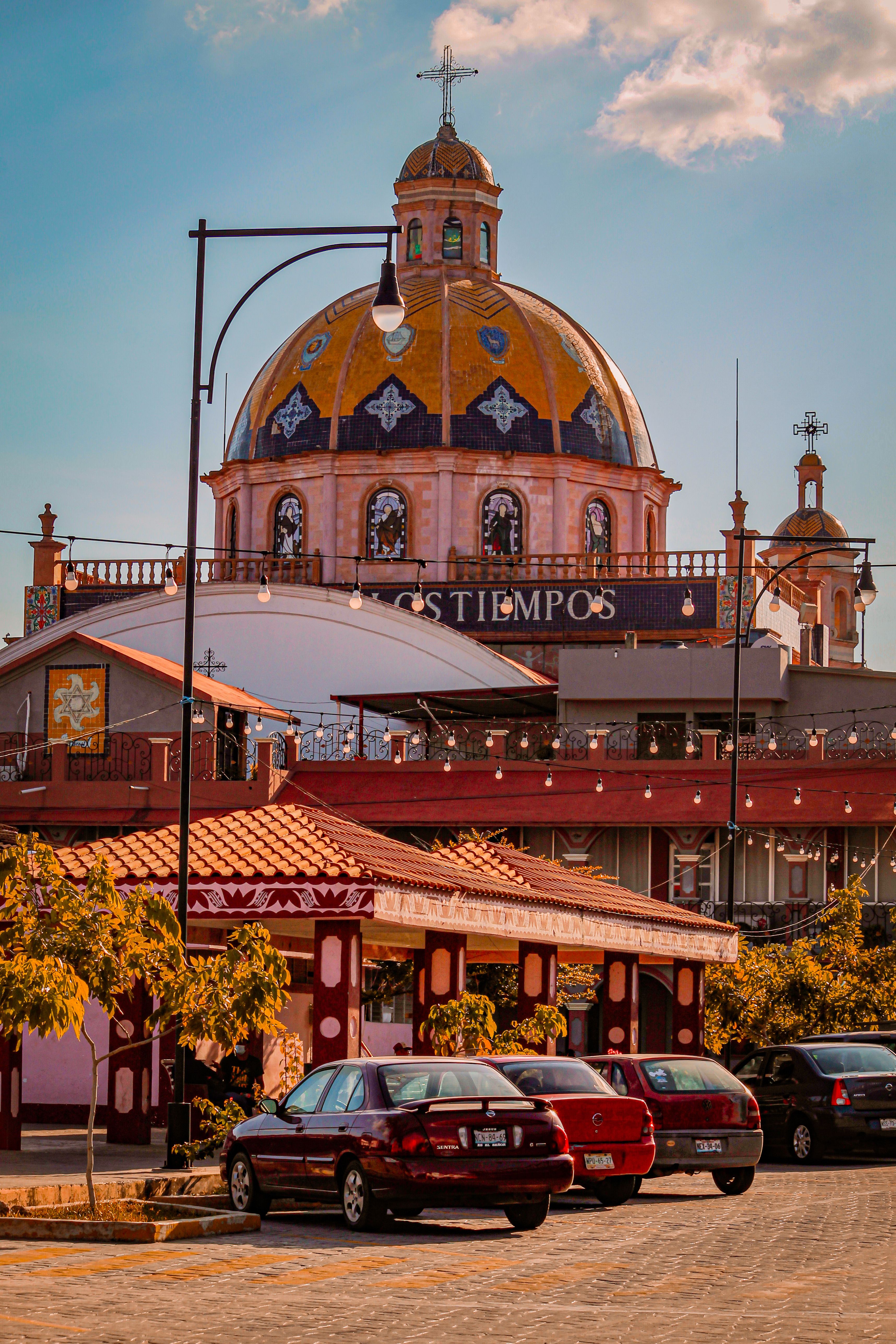 A church with a dome and cars parked in front · Free Stock Photo