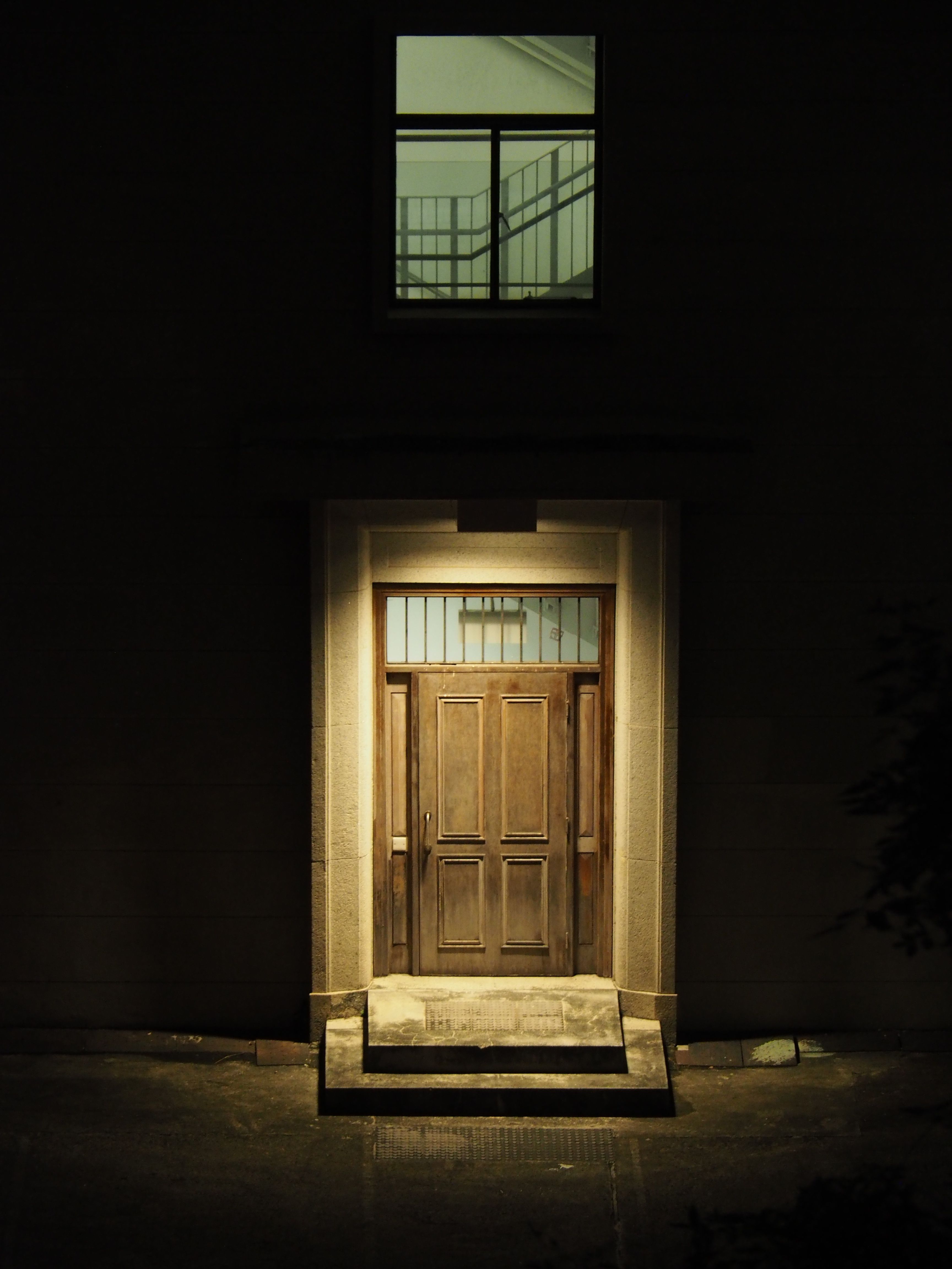 A door is open in the dark with a light on · Free Stock Photo