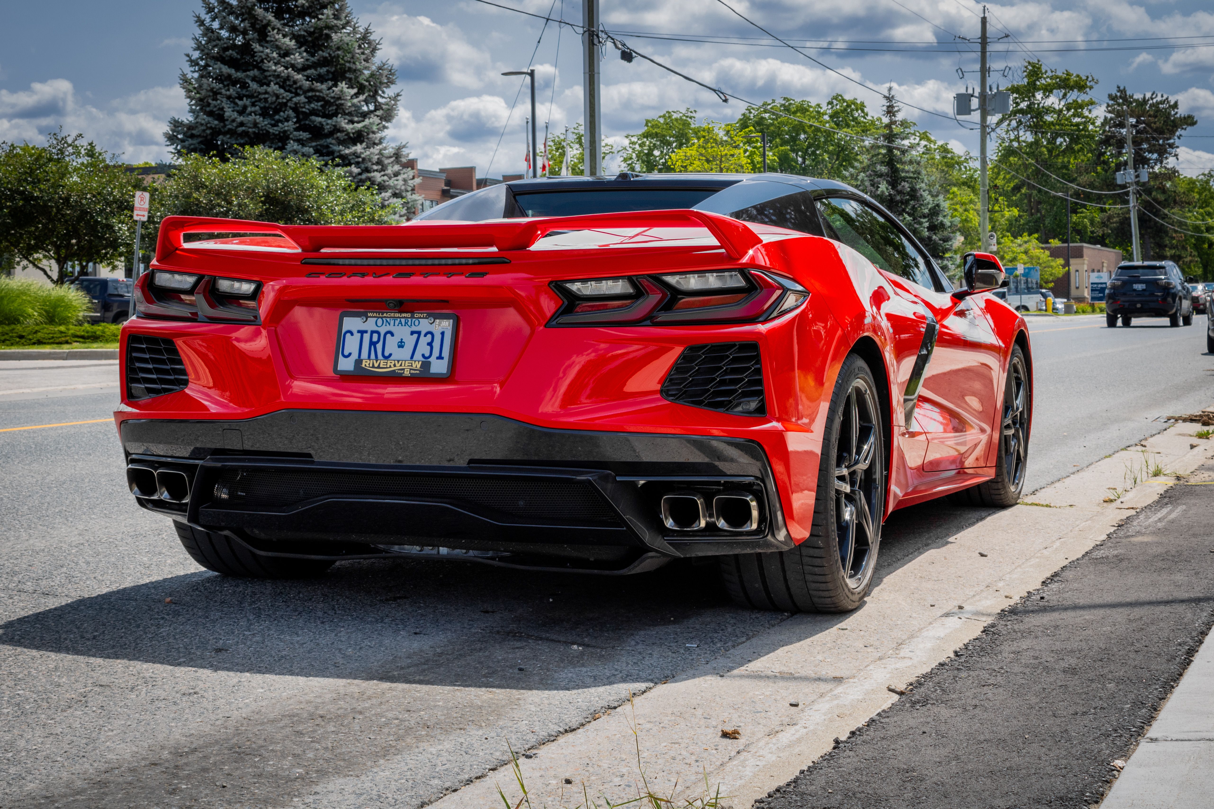 The rear end of a red sports car parked on the side of the road · Free ...
