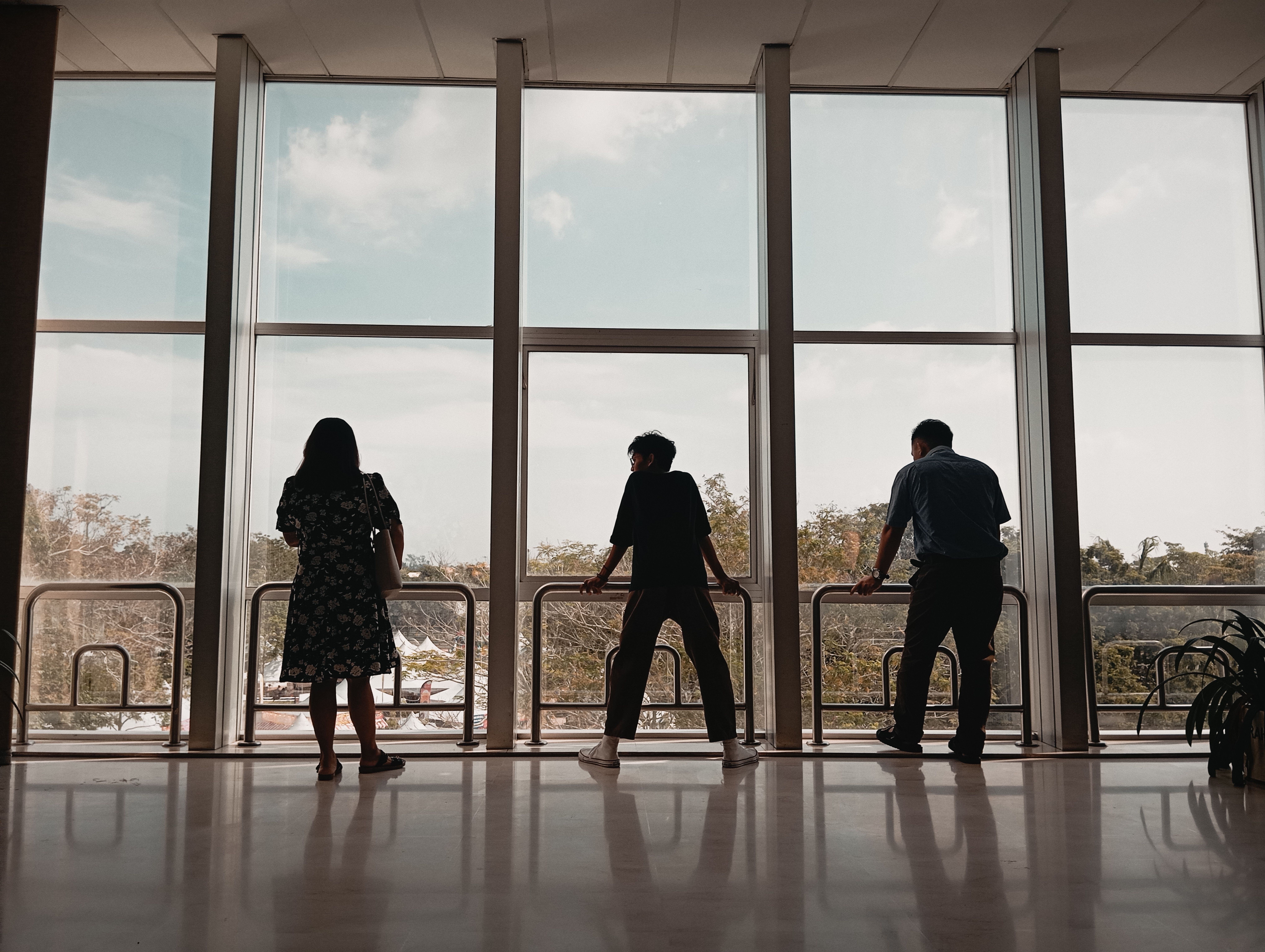 Silhouette of three people standing in front of large windows · Free ...