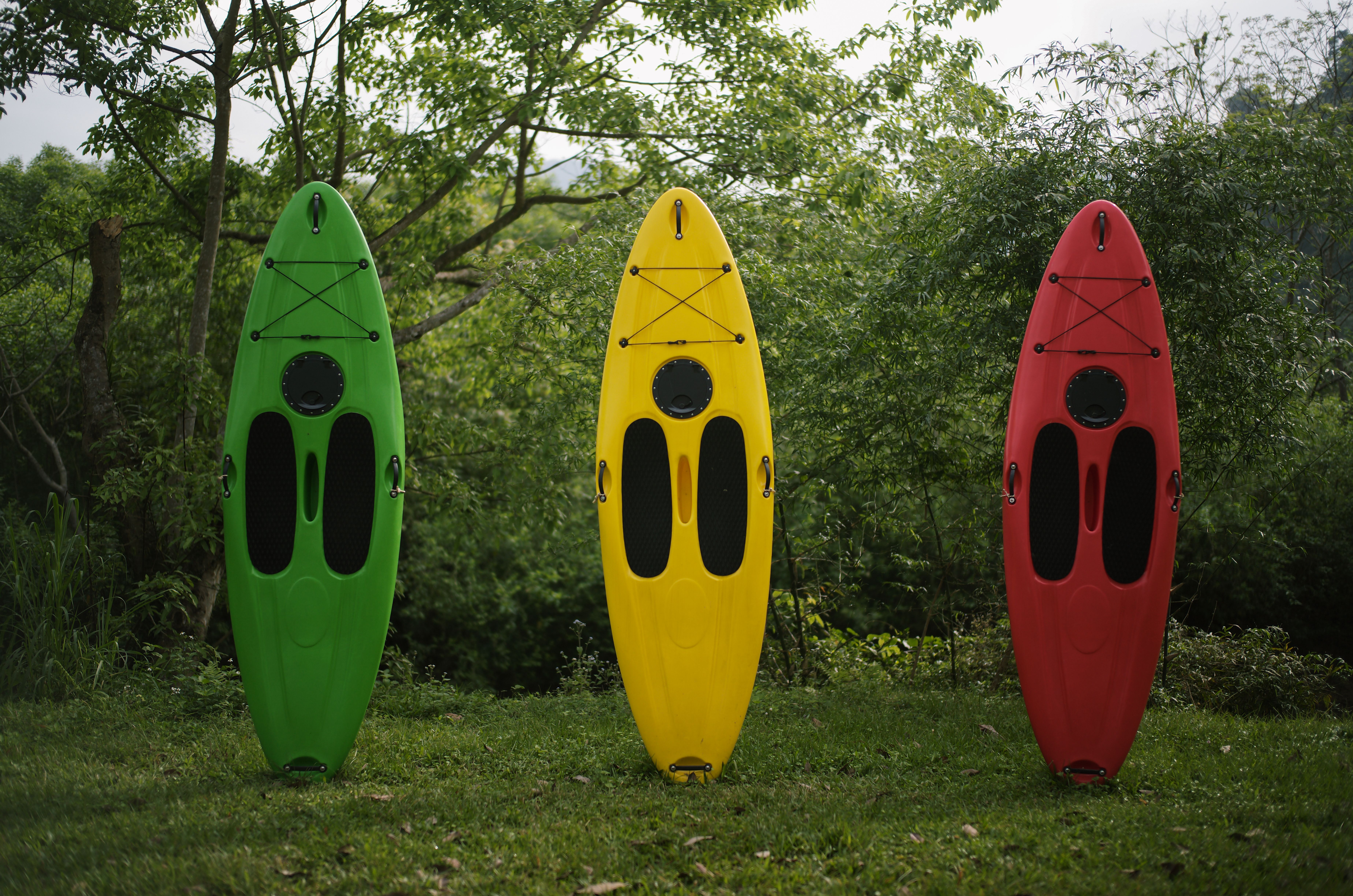 Three kayaks are lined up in the grass · Free Stock Photo