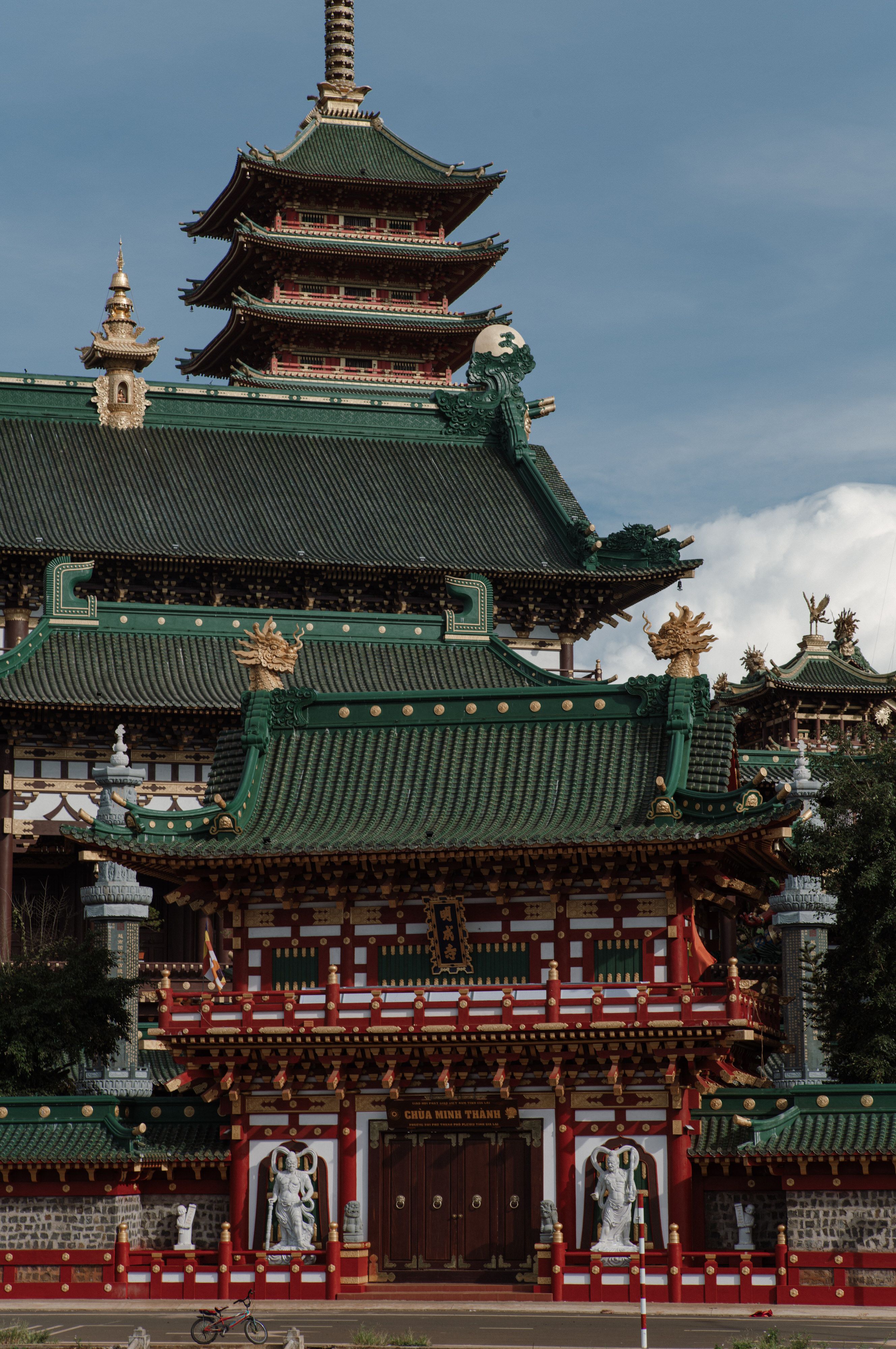 A large asian building with green and red roofs · Free Stock Photo