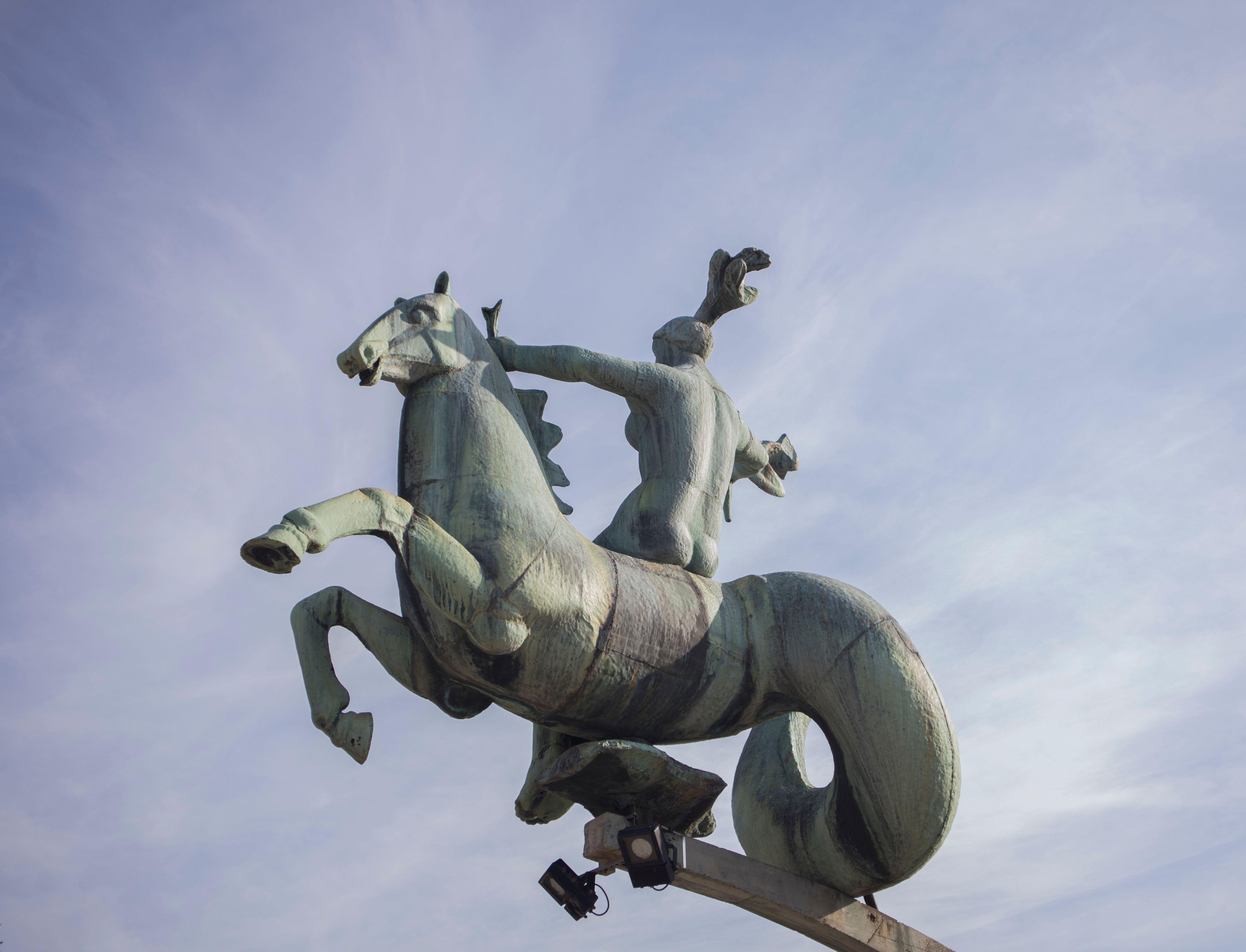 Dynamic Horse and Rider Bronze Sculpture Outdoors · Free Stock Photo